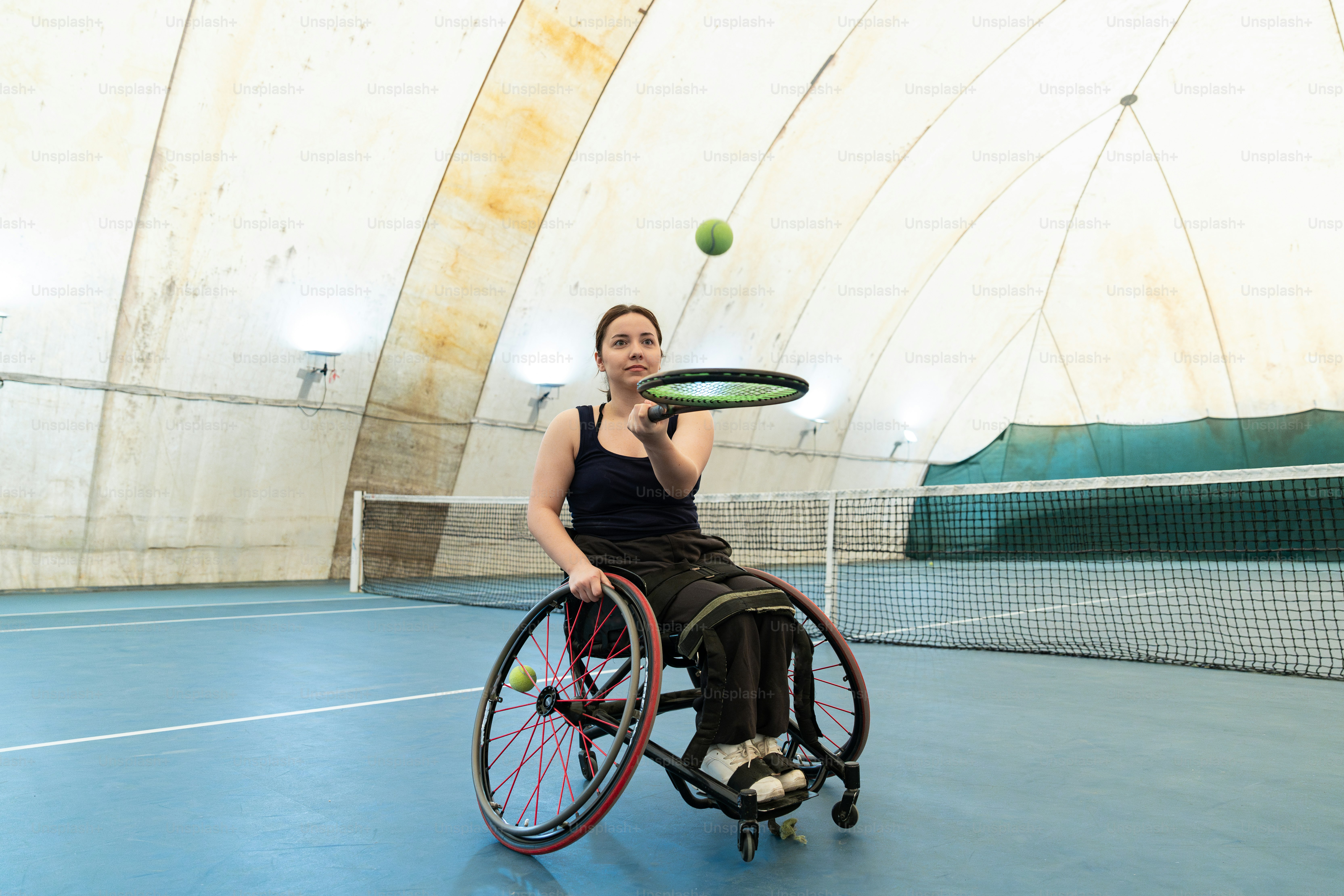A woman in a wheel chair holding a tennis racket photo – Sport Image on ...