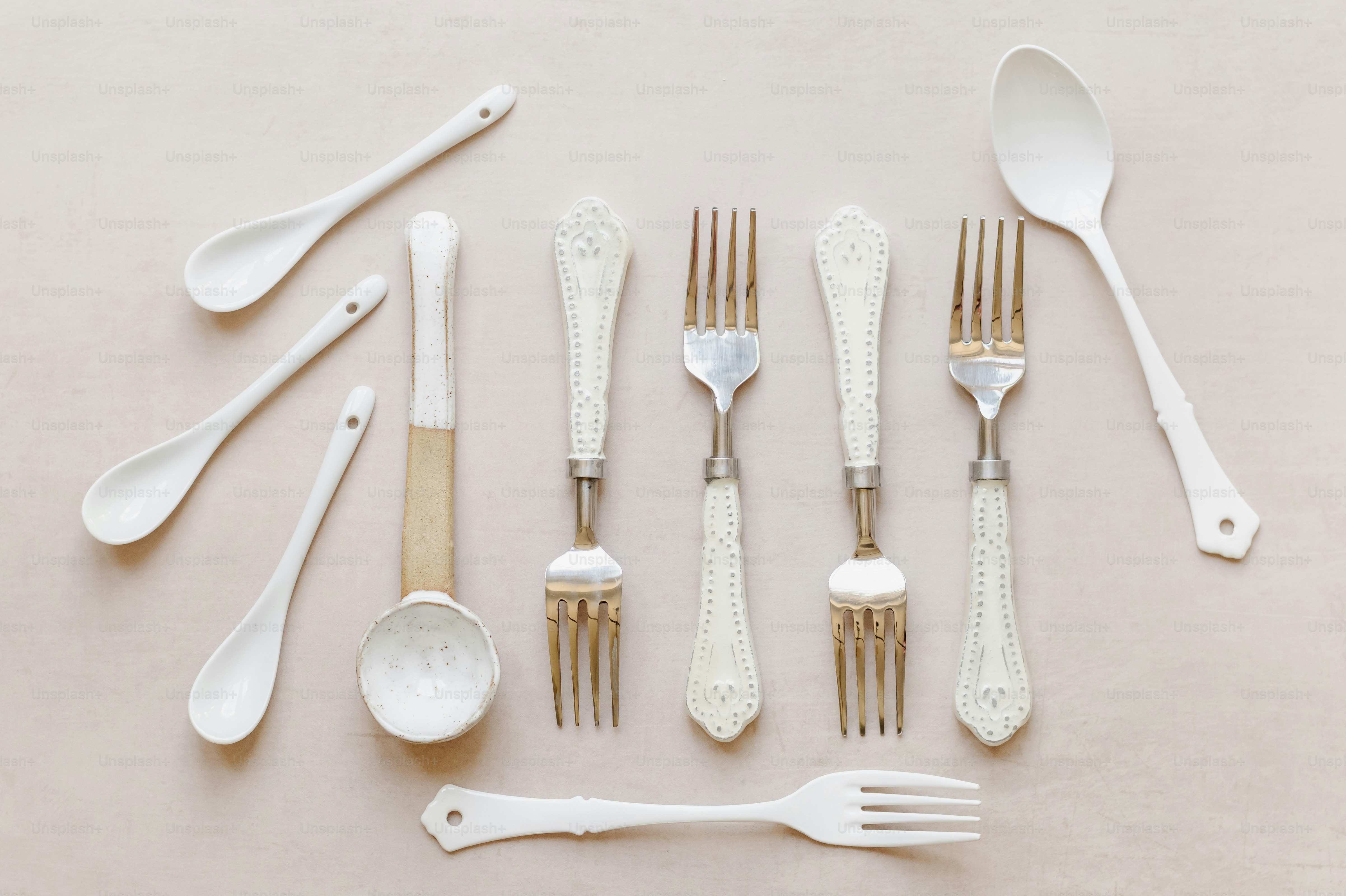 A table topped with lots of white utensils photo – Forks Image on Unsplash