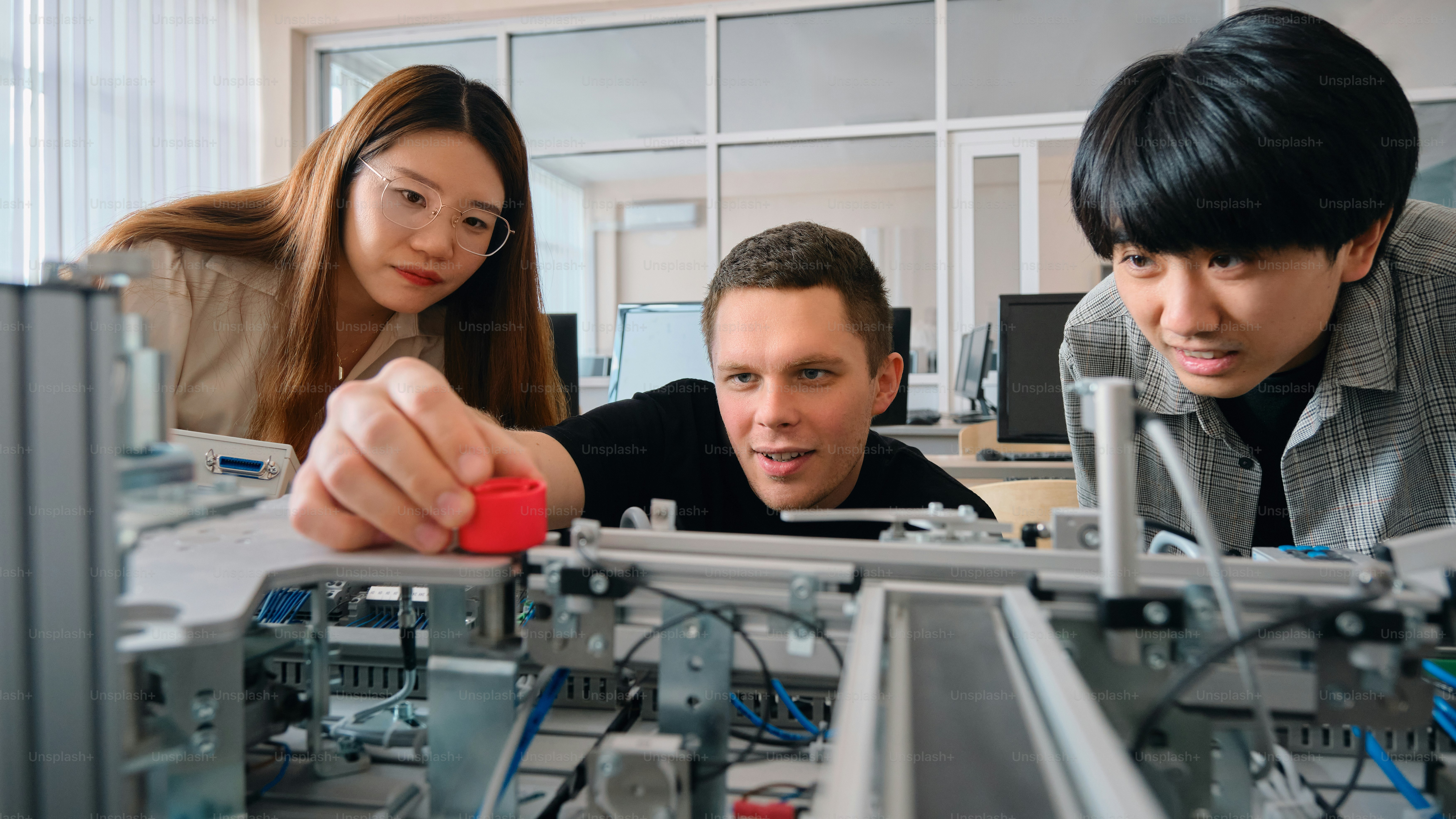 A group of people sitting around a table with laptops photo ...