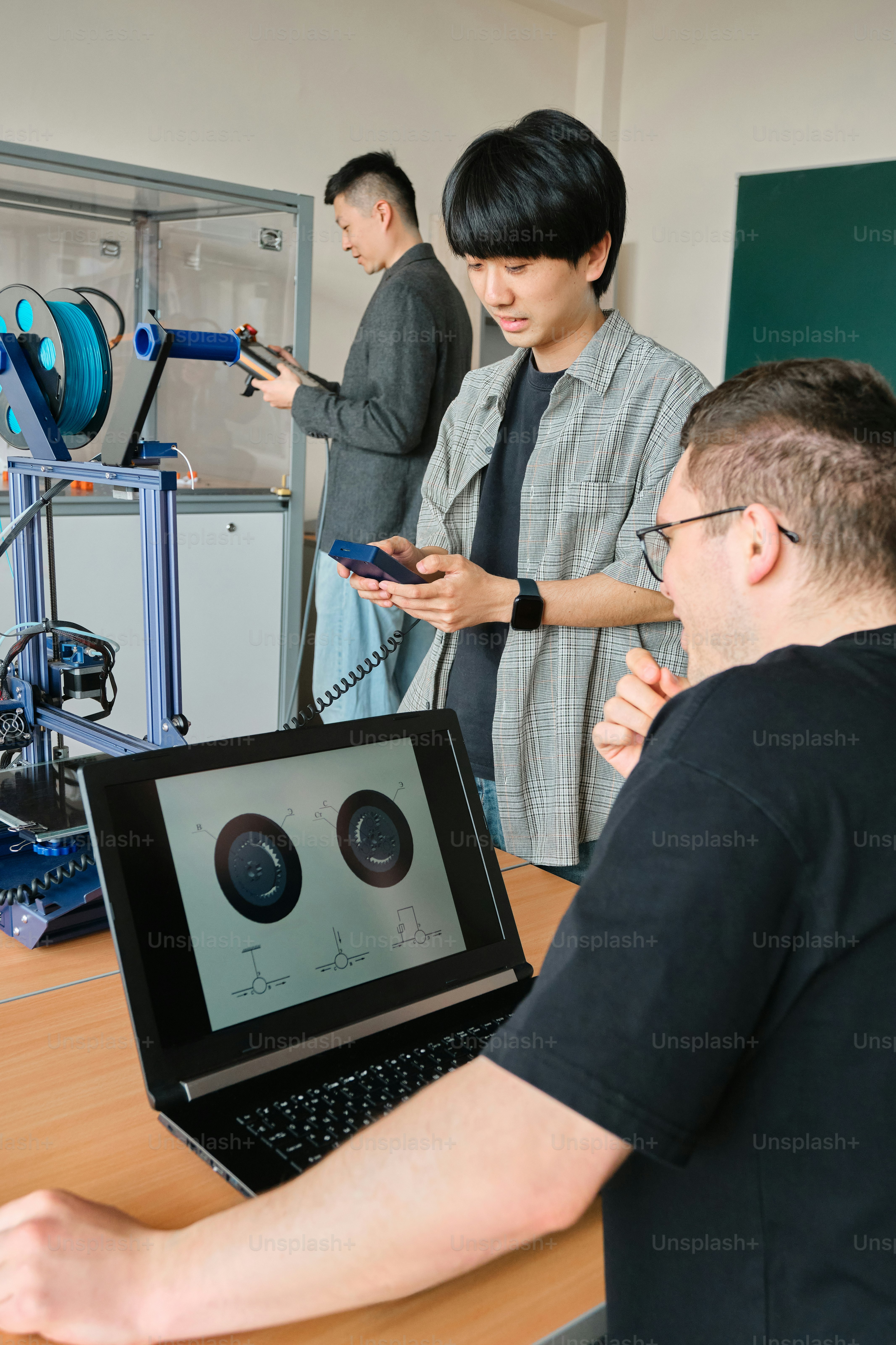 A group of people sitting around a table with laptops photo ...