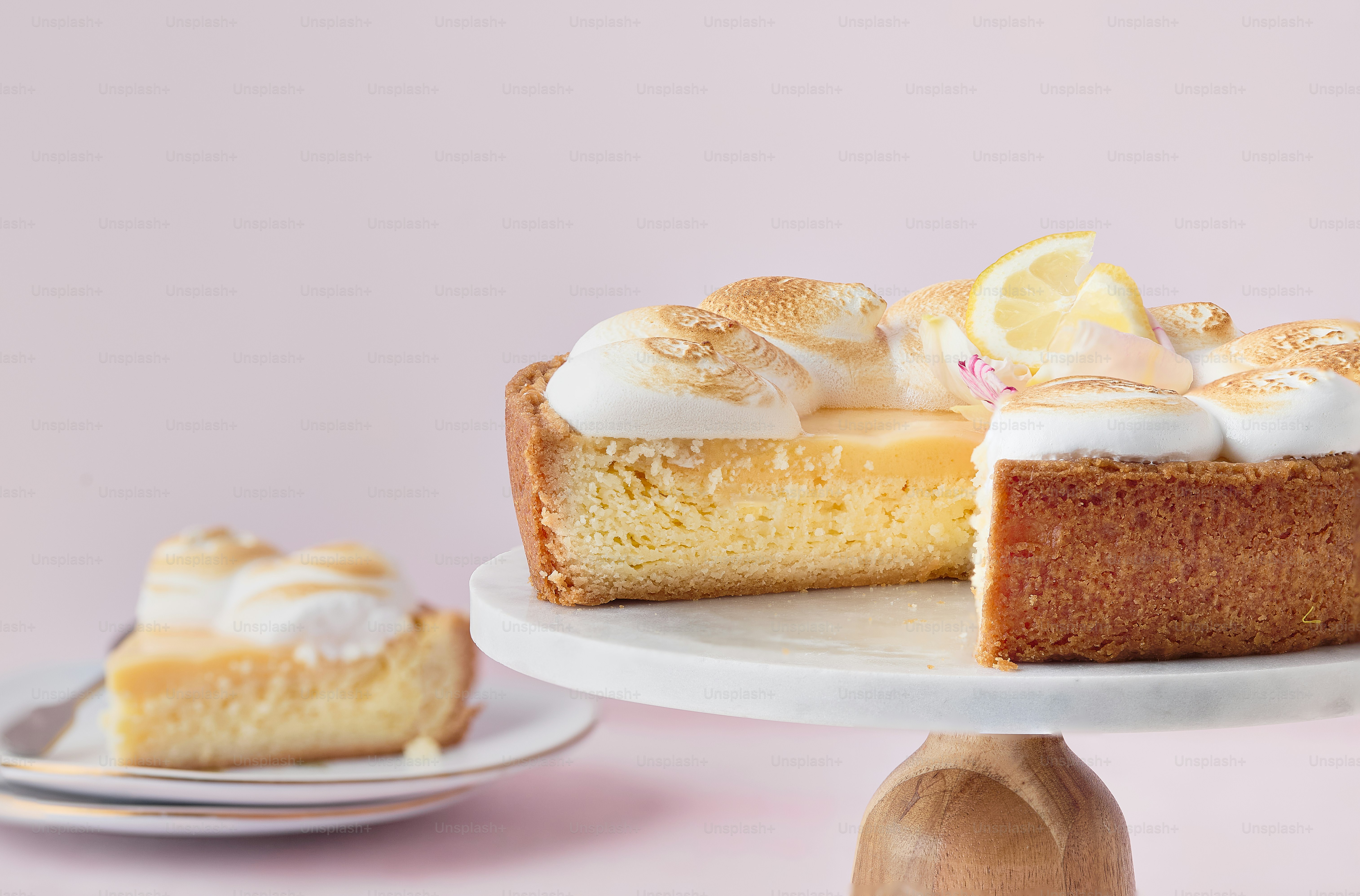 A table topped with a cake covered in lemons photo – Lemon meringue ...