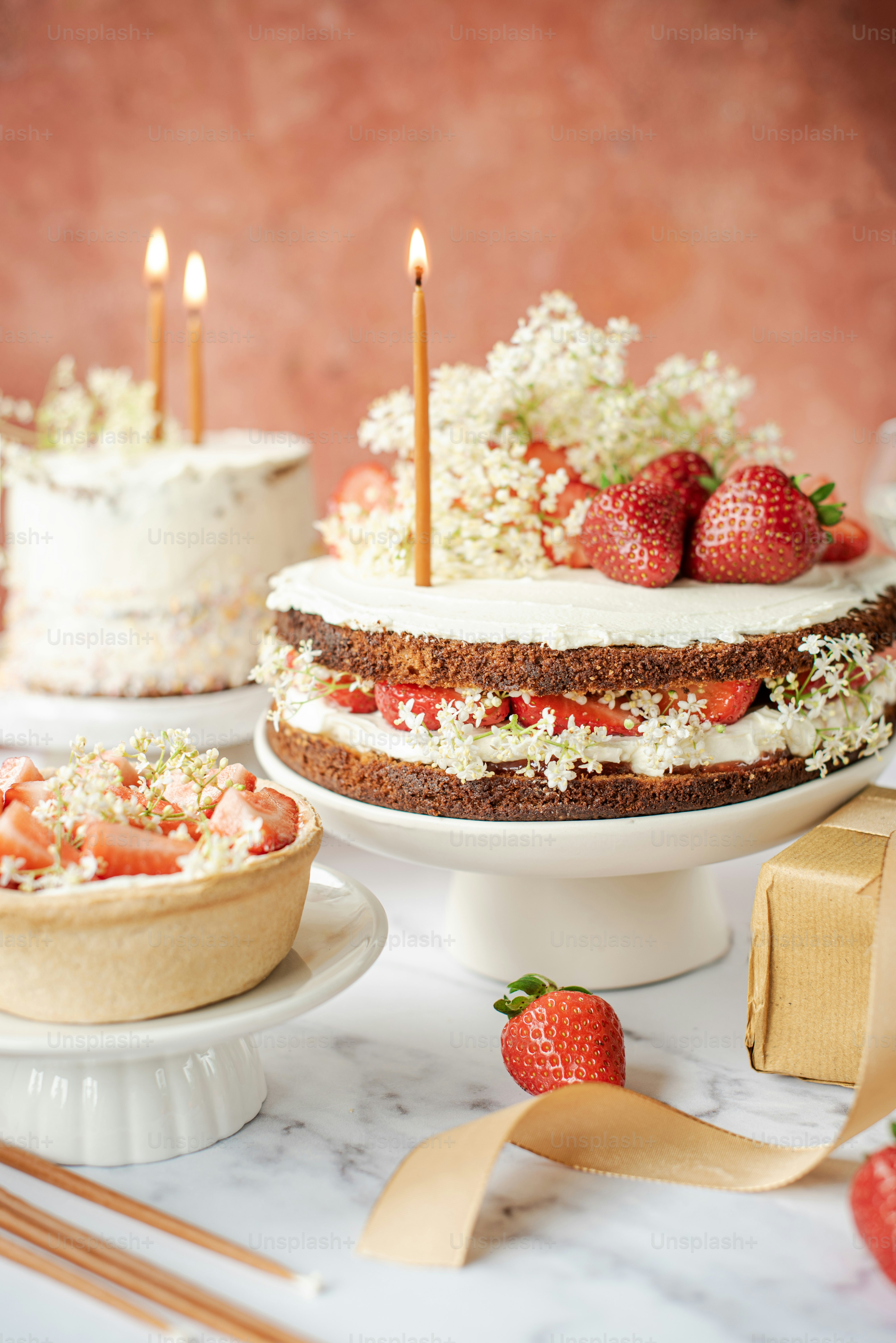 A table topped with three cakes covered in frosting photo – Birthday ...