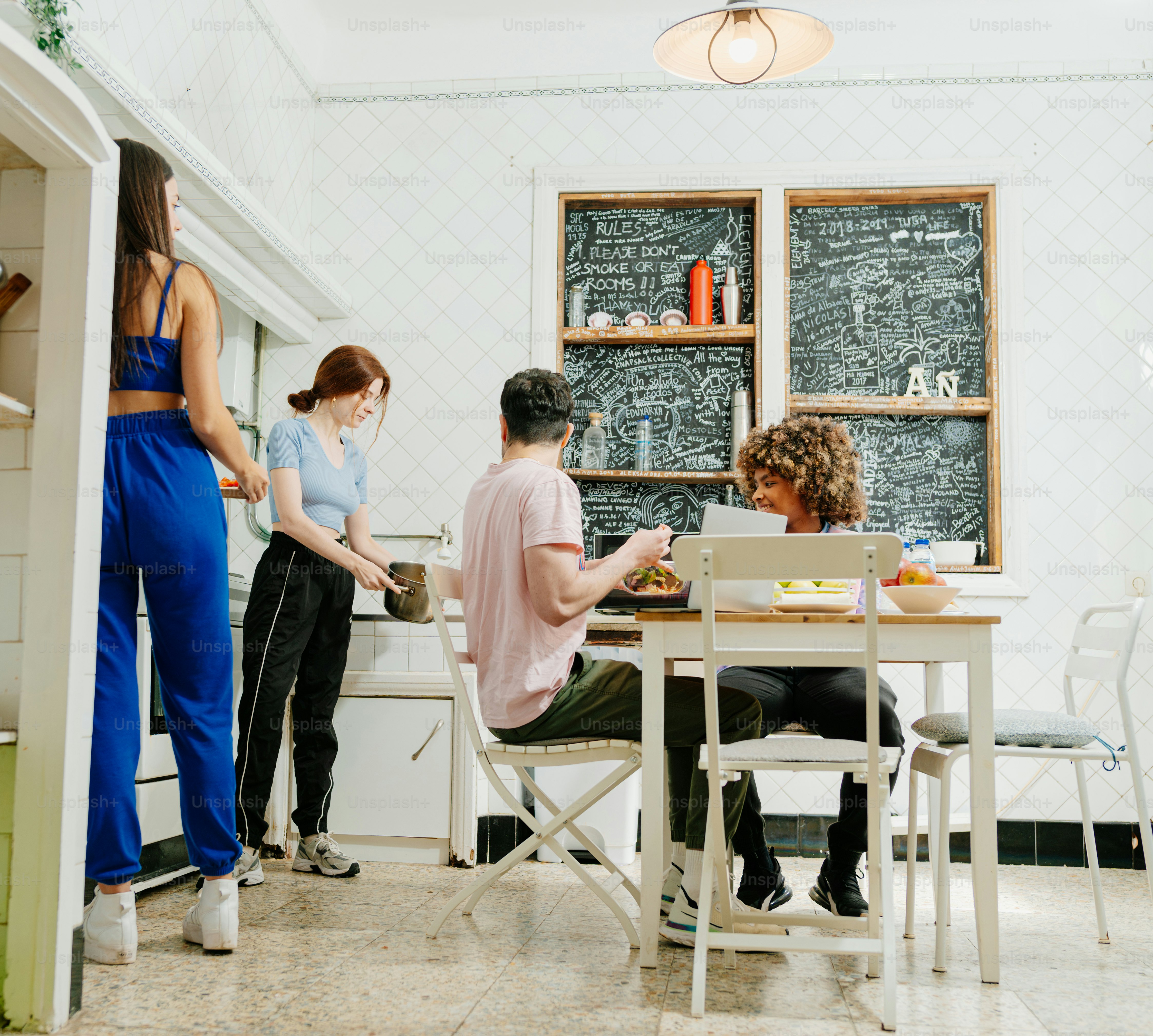A group of people sitting at a table in a kitchen photo – Dormitory ...