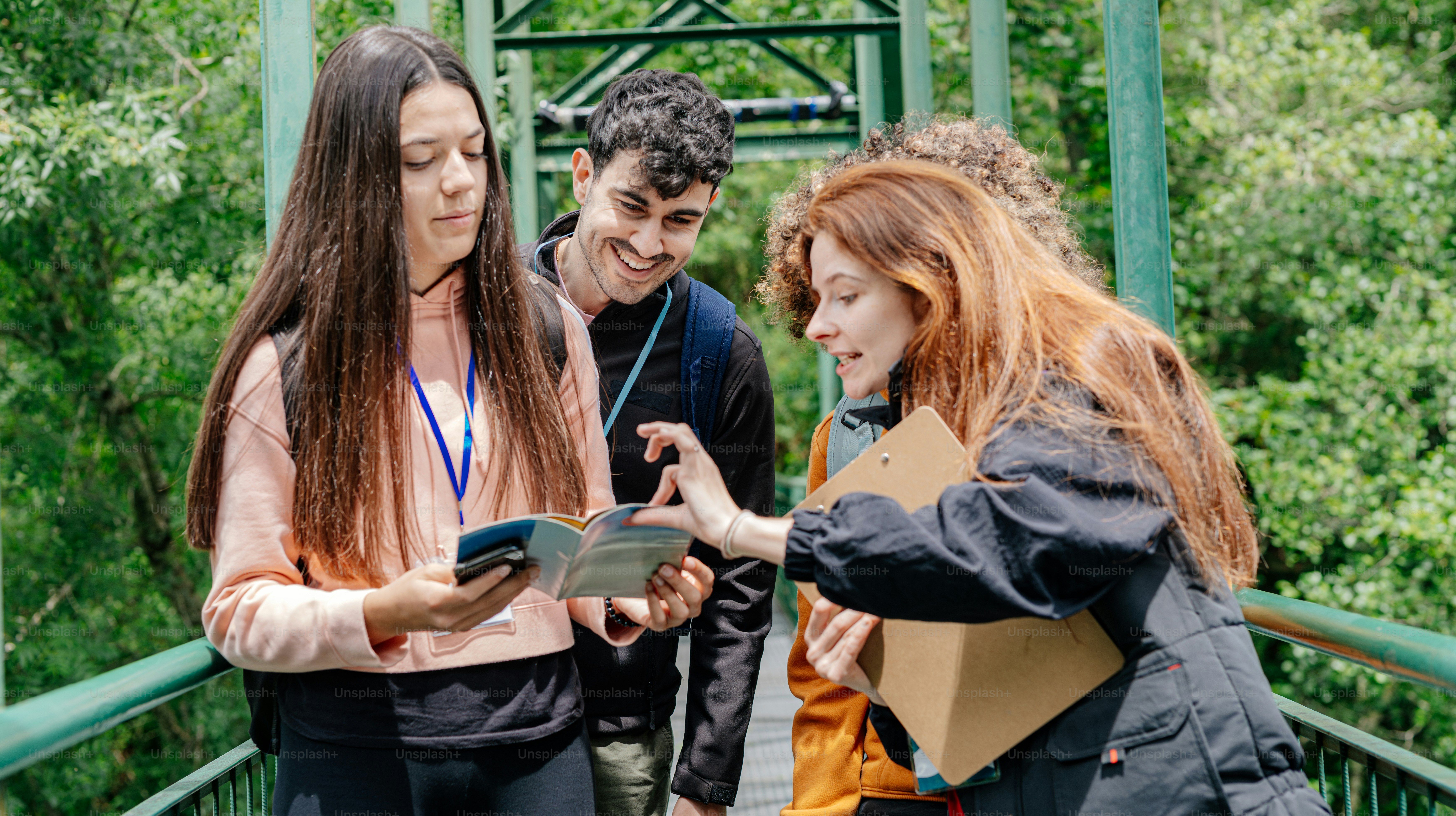 A group of people standing around a map photo – Group travel Image on ...