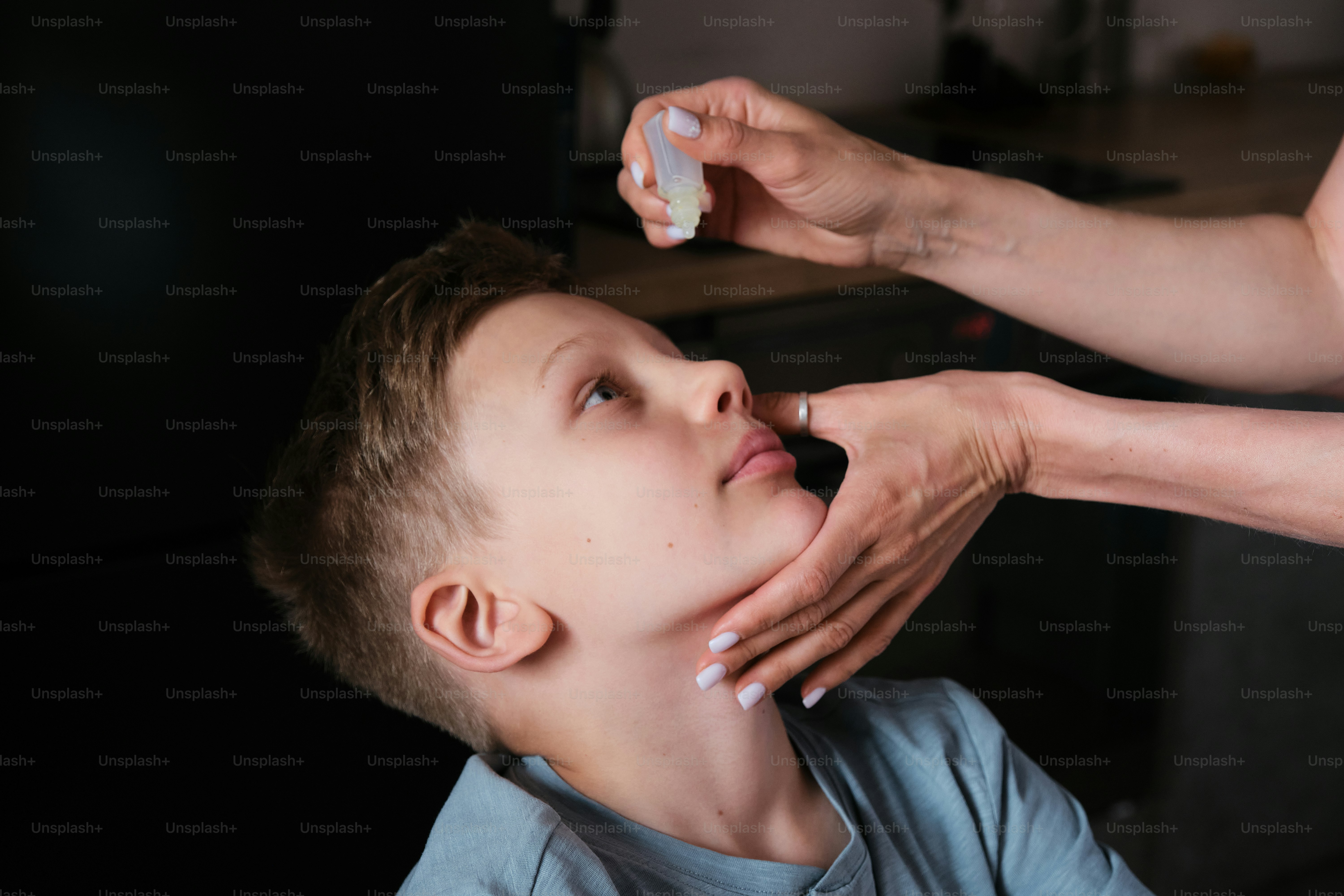 A young boy getting his hair brushed by a woman photo – Health Image on ...