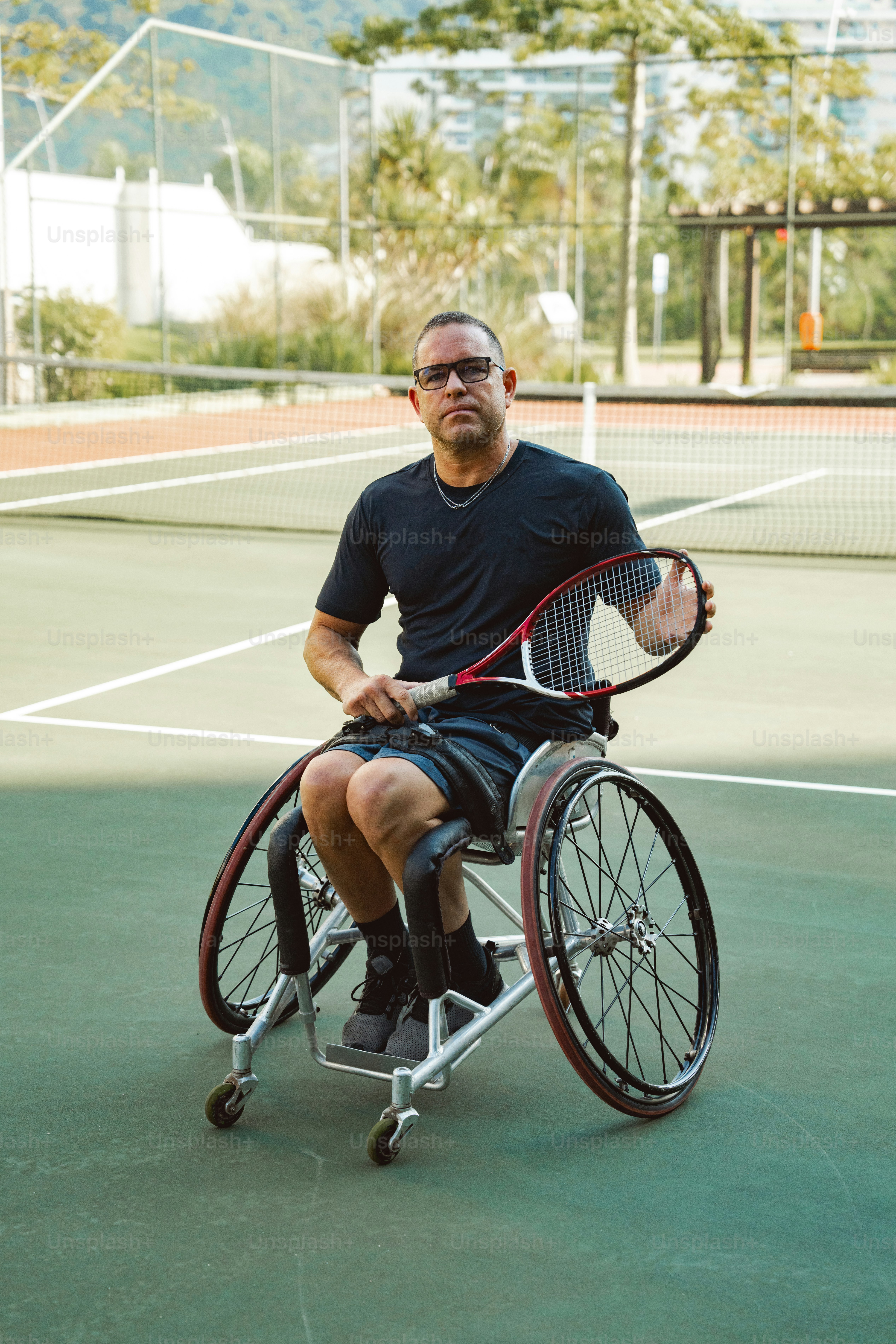 A man in a wheelchair holding a tennis racket photo – Disability Image ...
