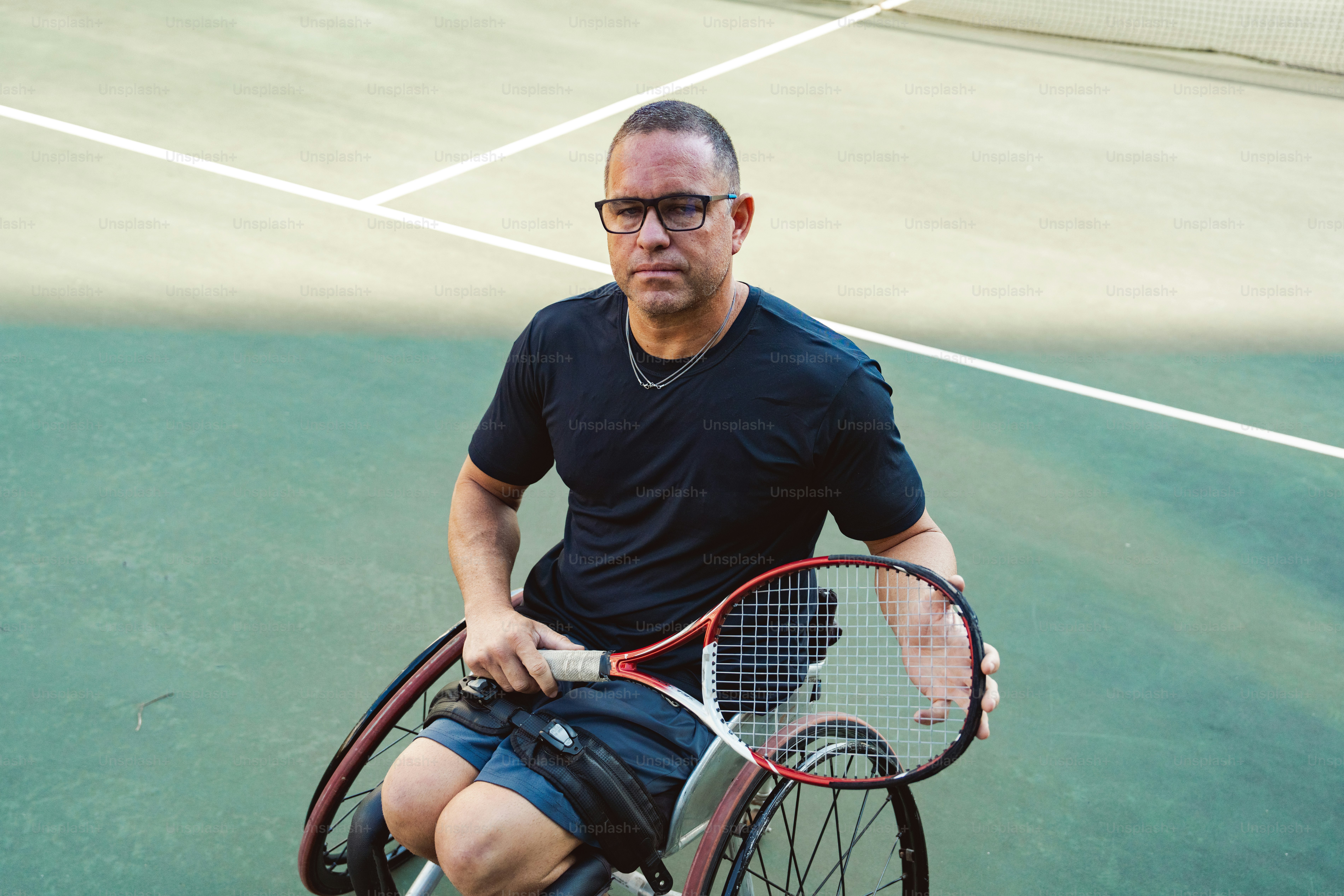 A man in a wheel chair holding a tennis racket photo – Athlete Image on ...