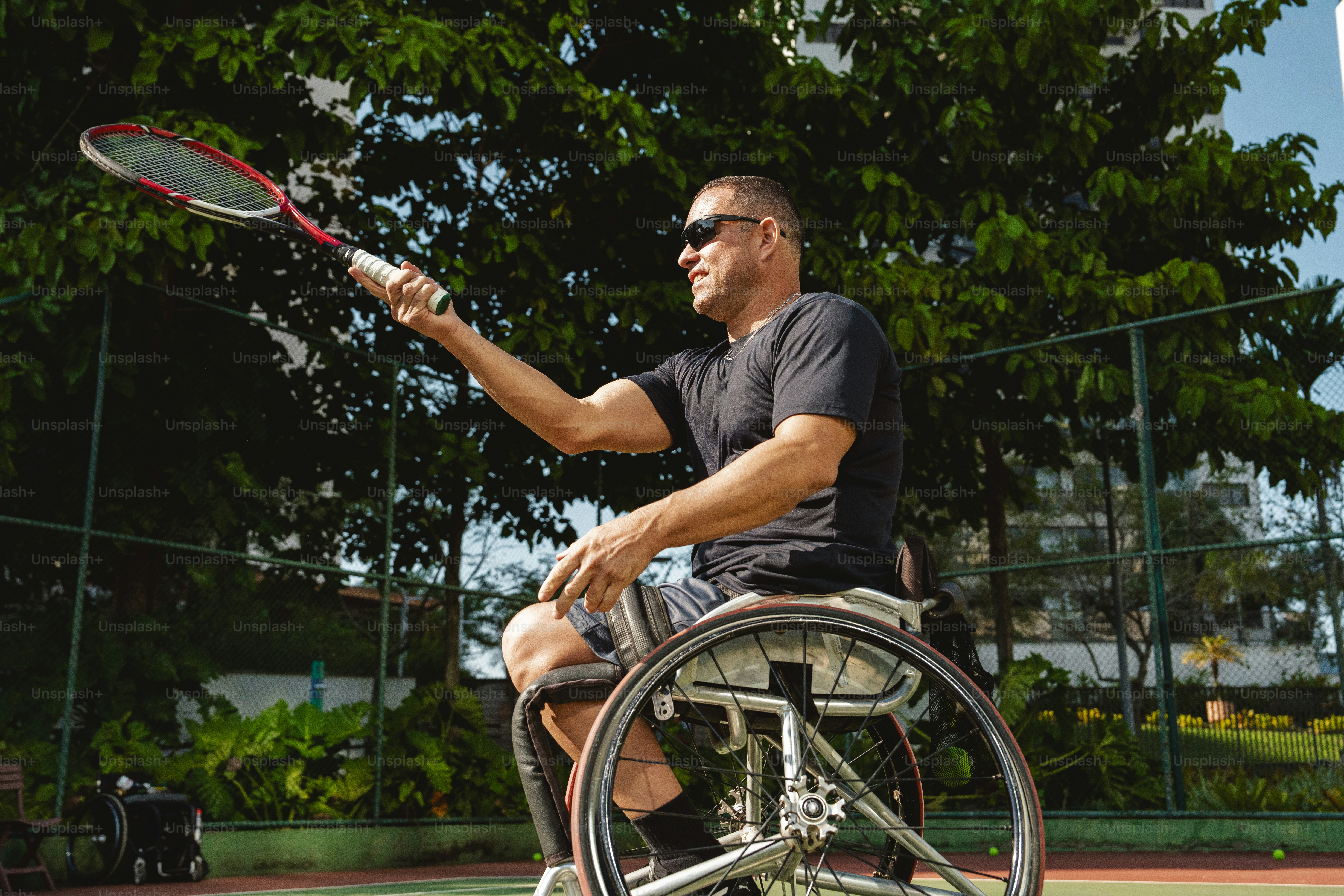 A man in a wheel chair holding a tennis racket photo – Athlete Image on ...