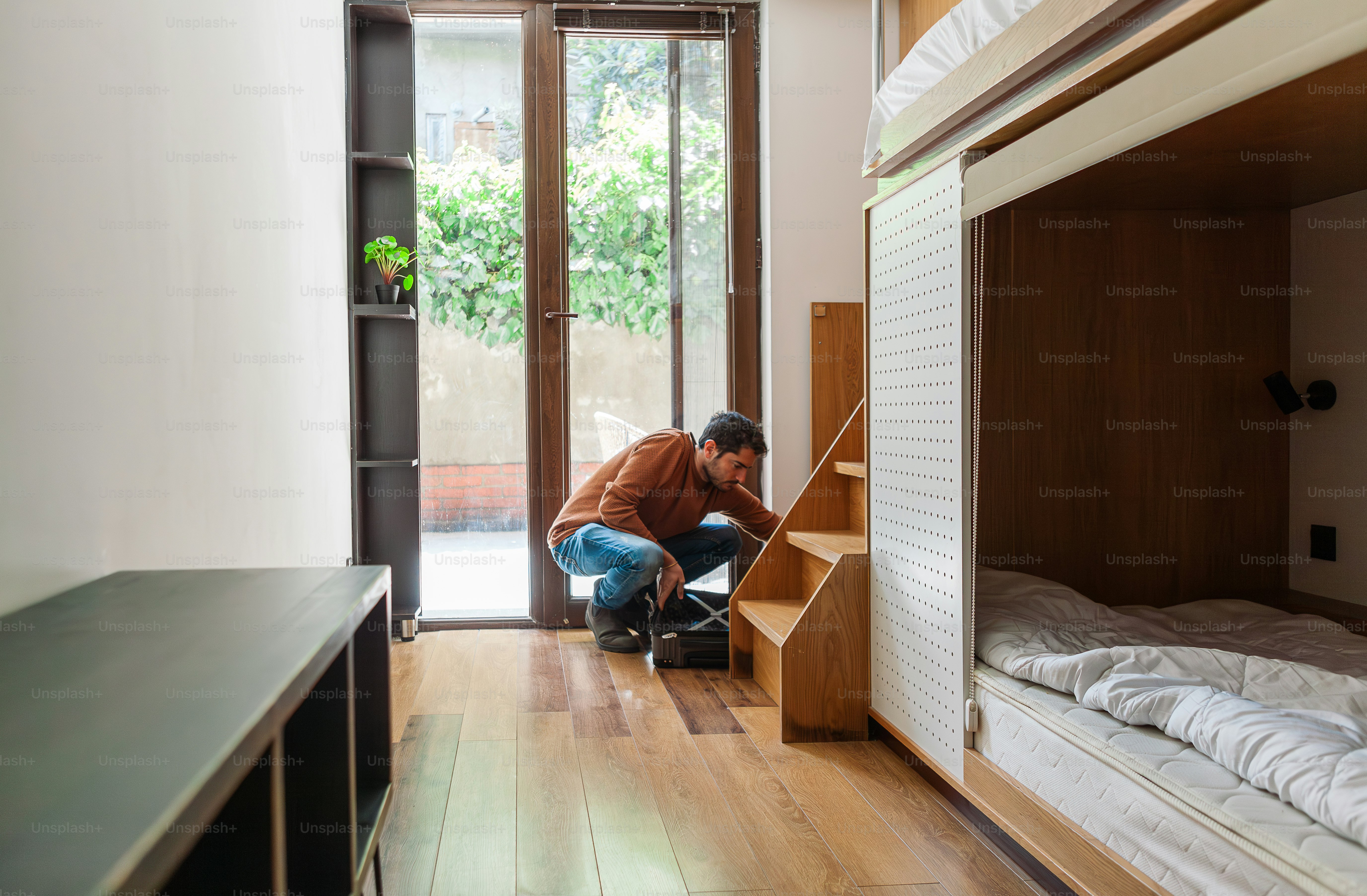 A man kneeling down in front of a bunk bed photo – Adventure Image on ...