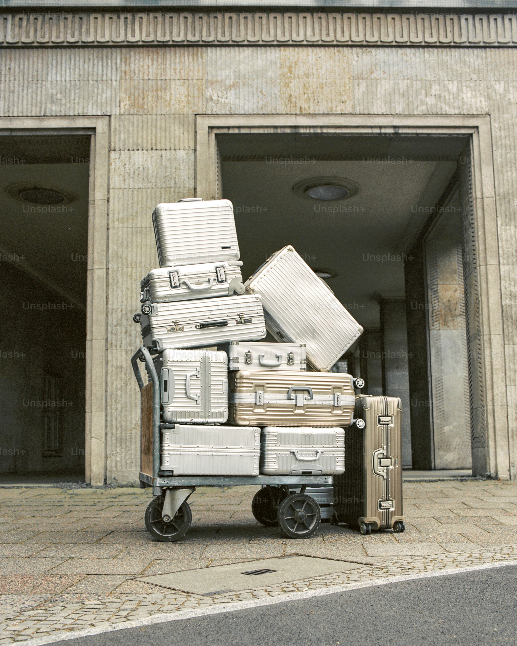 A pile of luggage sitting on top of a dolly photo – Luggage Image on ...