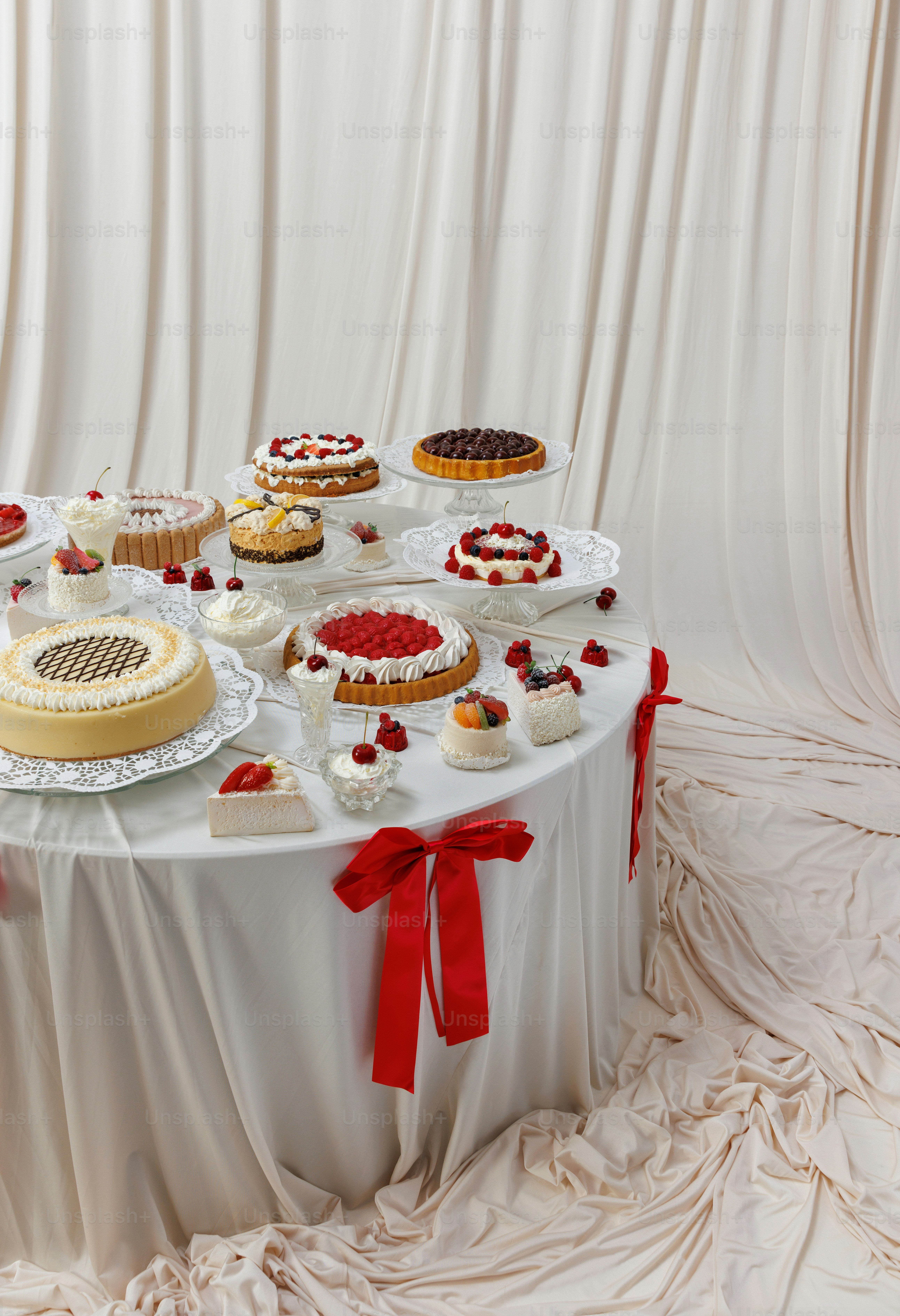 A table topped with lots of cakes and pies photo – Red bow Image on ...