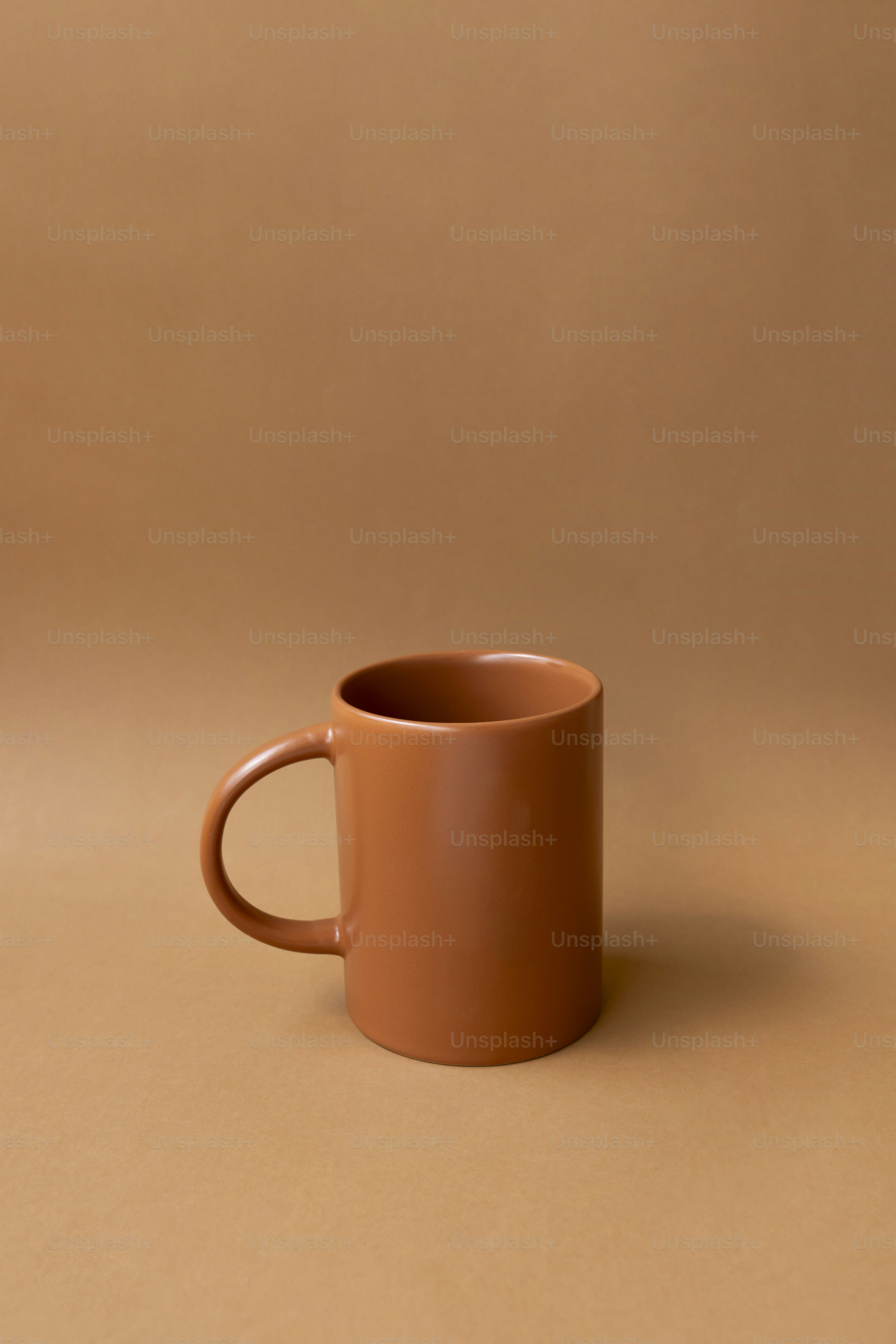 A brown coffee cup sitting on top of a table photo – Product Image on ...