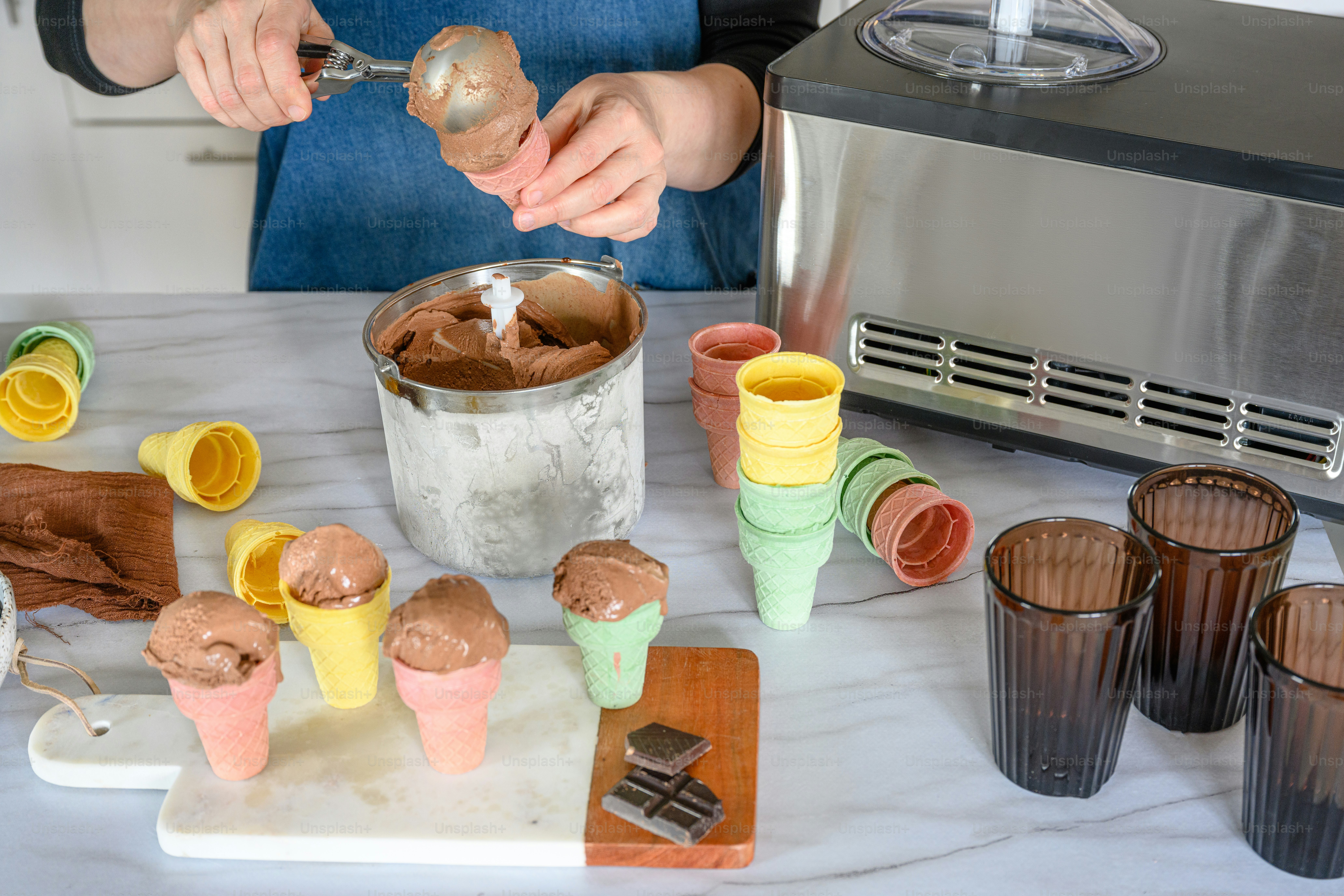 A person scooping chocolate into a pot of ice cream photo – Chocolate ...