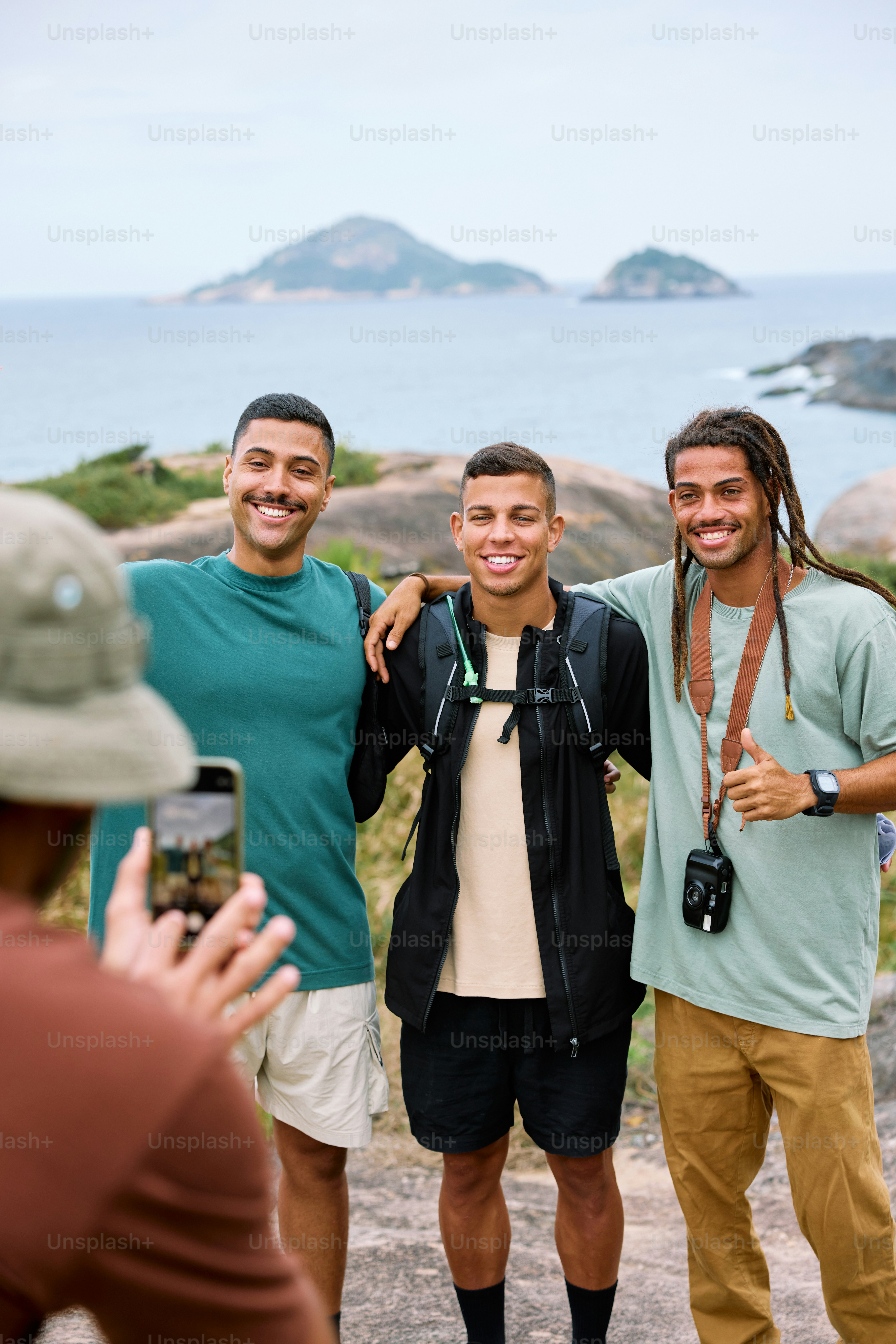 A group of three men standing next to each other photo – Tour guide ...