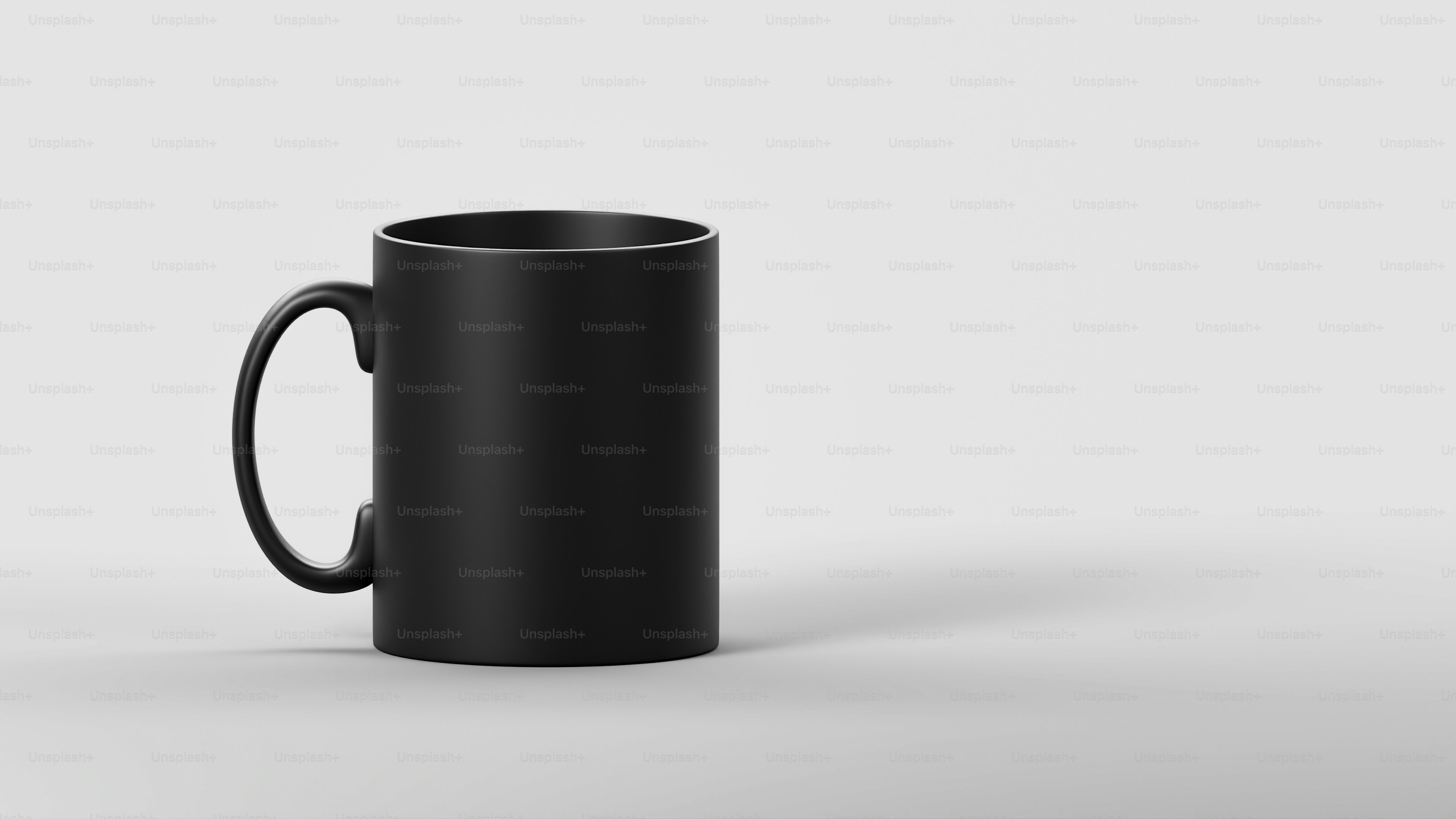 A black coffee mug sitting on top of a white table photo – Presentation ...