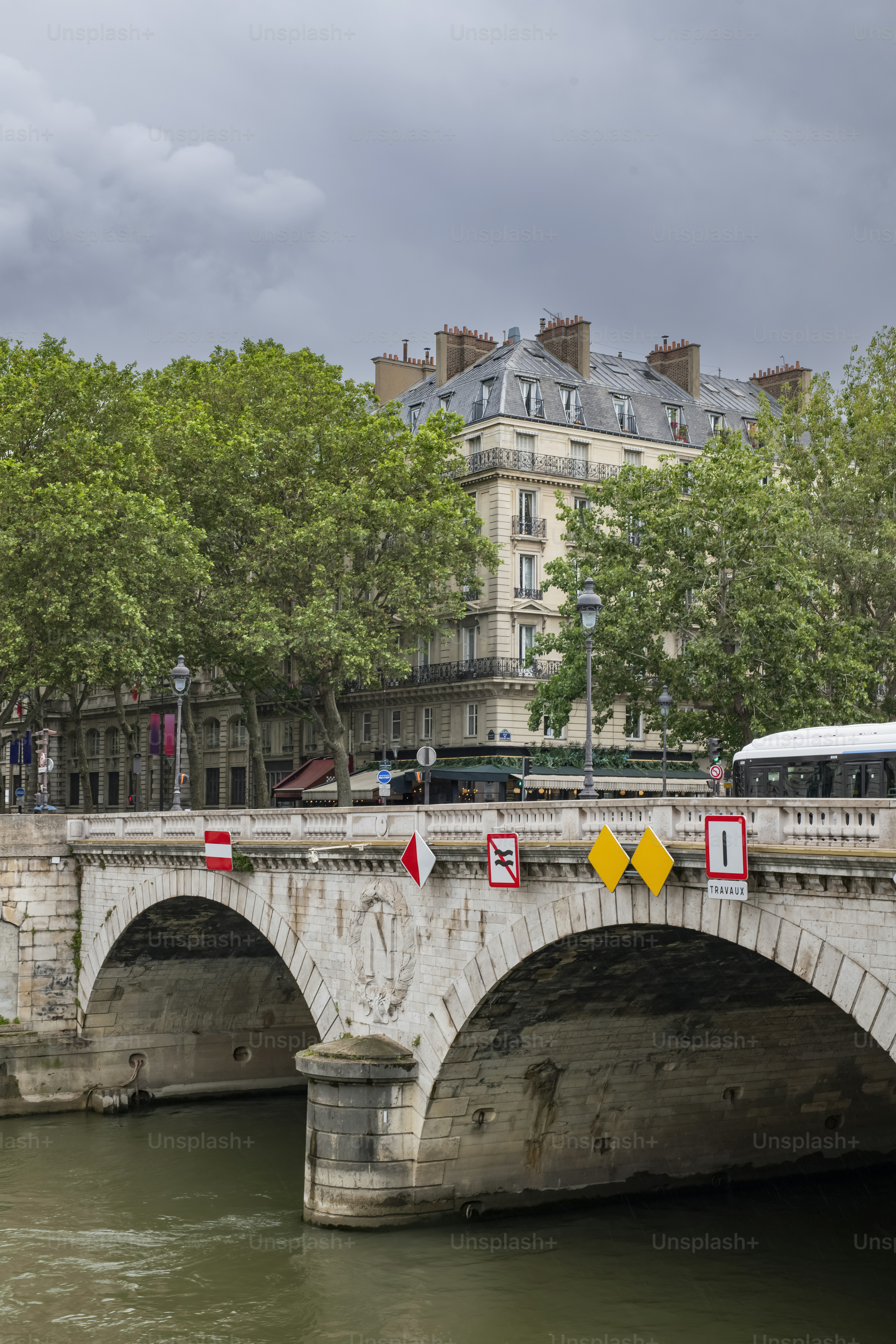 A bridge over a river with a bus on it photo – Île de la cité Image on ...