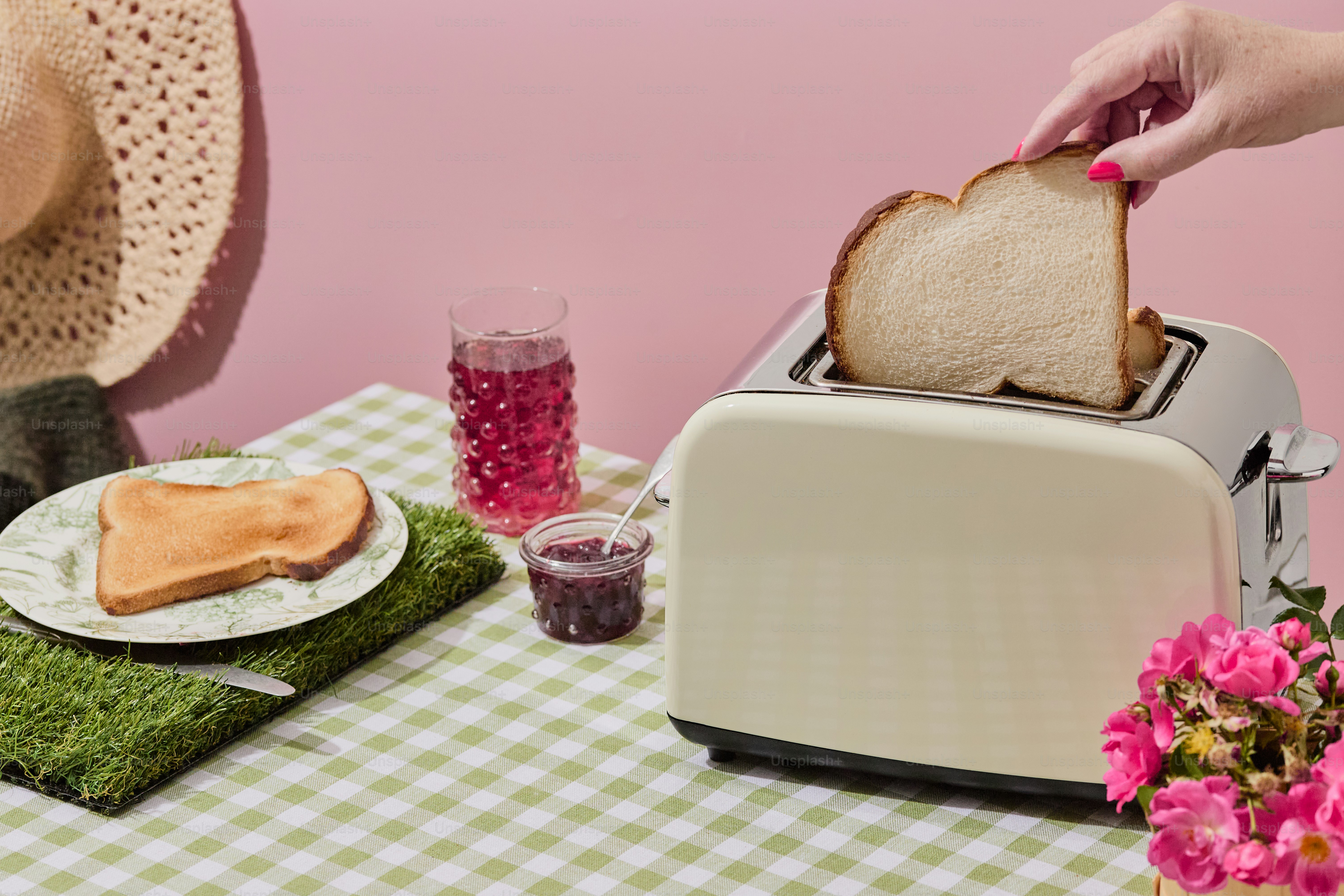 A person is putting a slice of bread into a toaster photo – Toast Image ...
