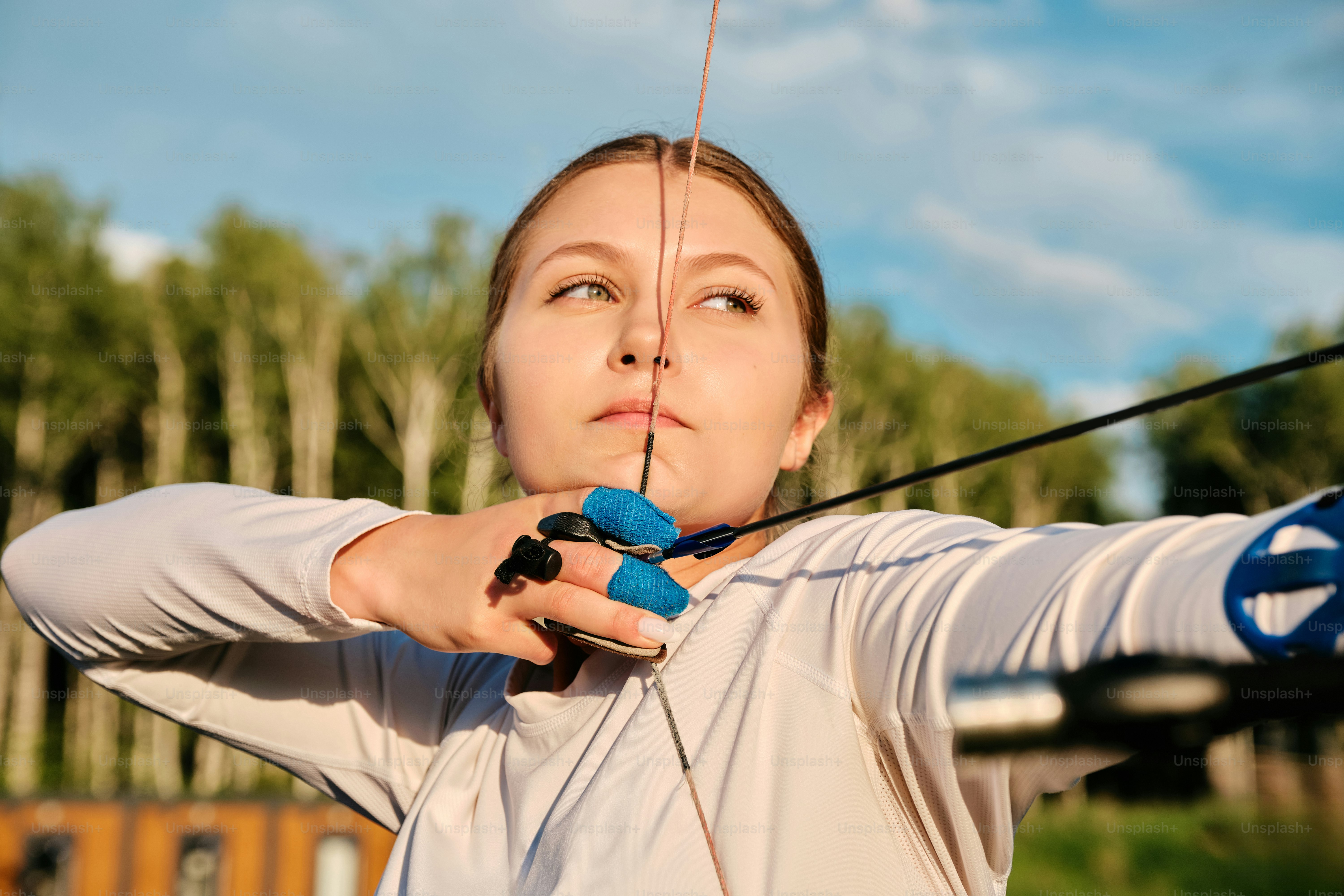 A woman is aiming a bow at a target photo – Archery Image on Unsplash