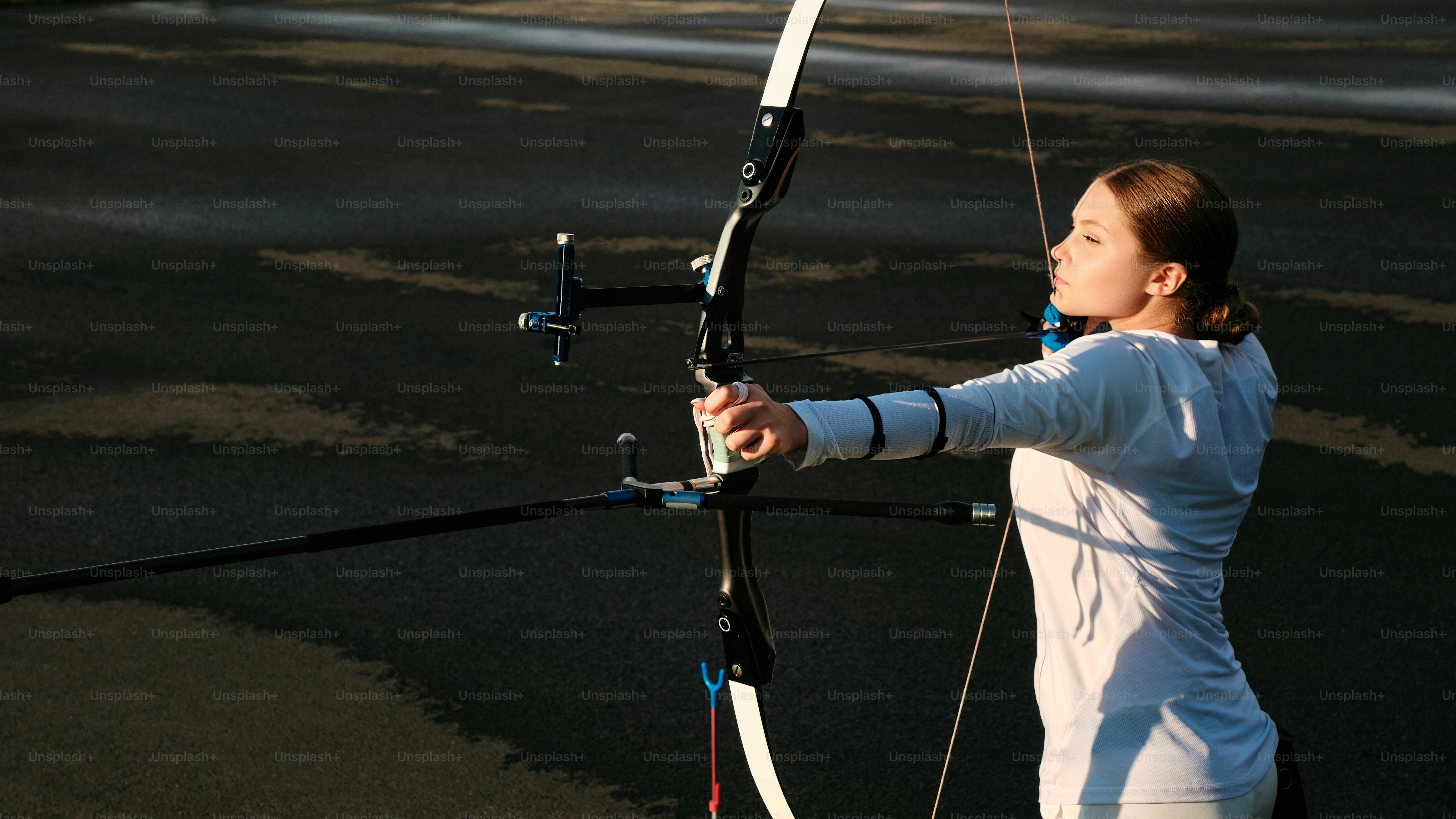 A young girl is practicing her archery skills photo – Archer Image on ...