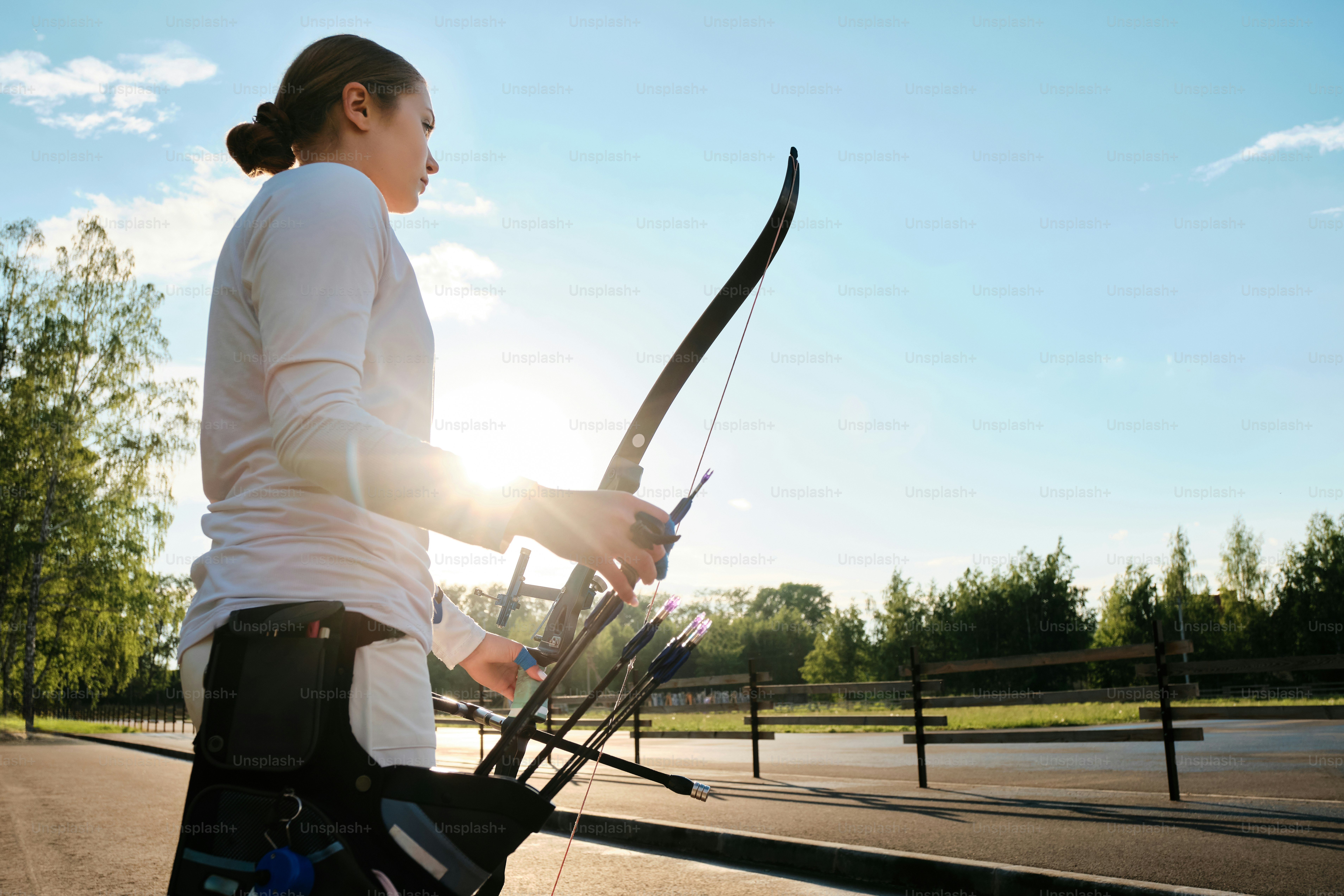 A woman holding a bow and arrow in her hands photo – Archer Image on ...