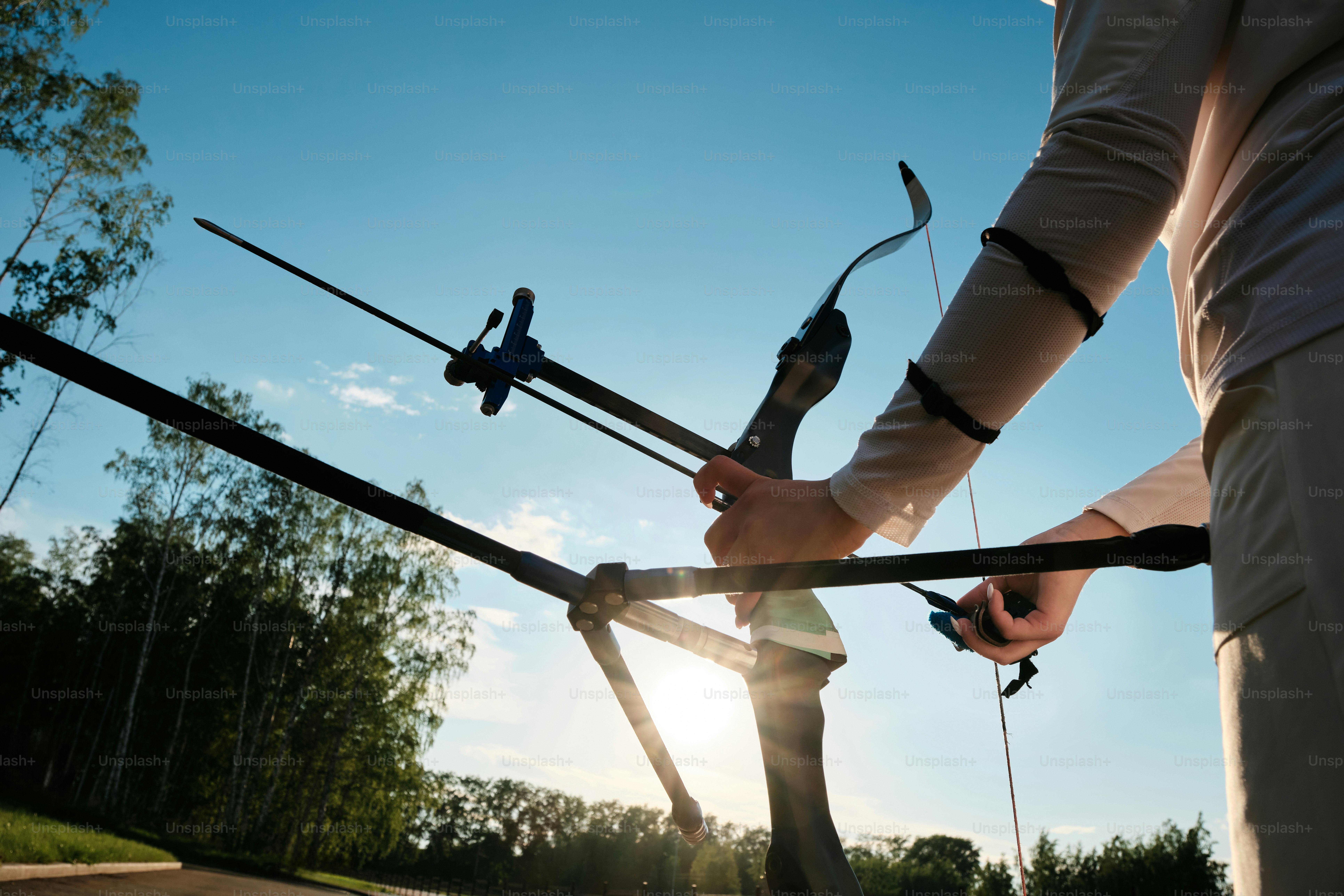 A person holding a bow and arrow in their hands photo – Archer Image on ...