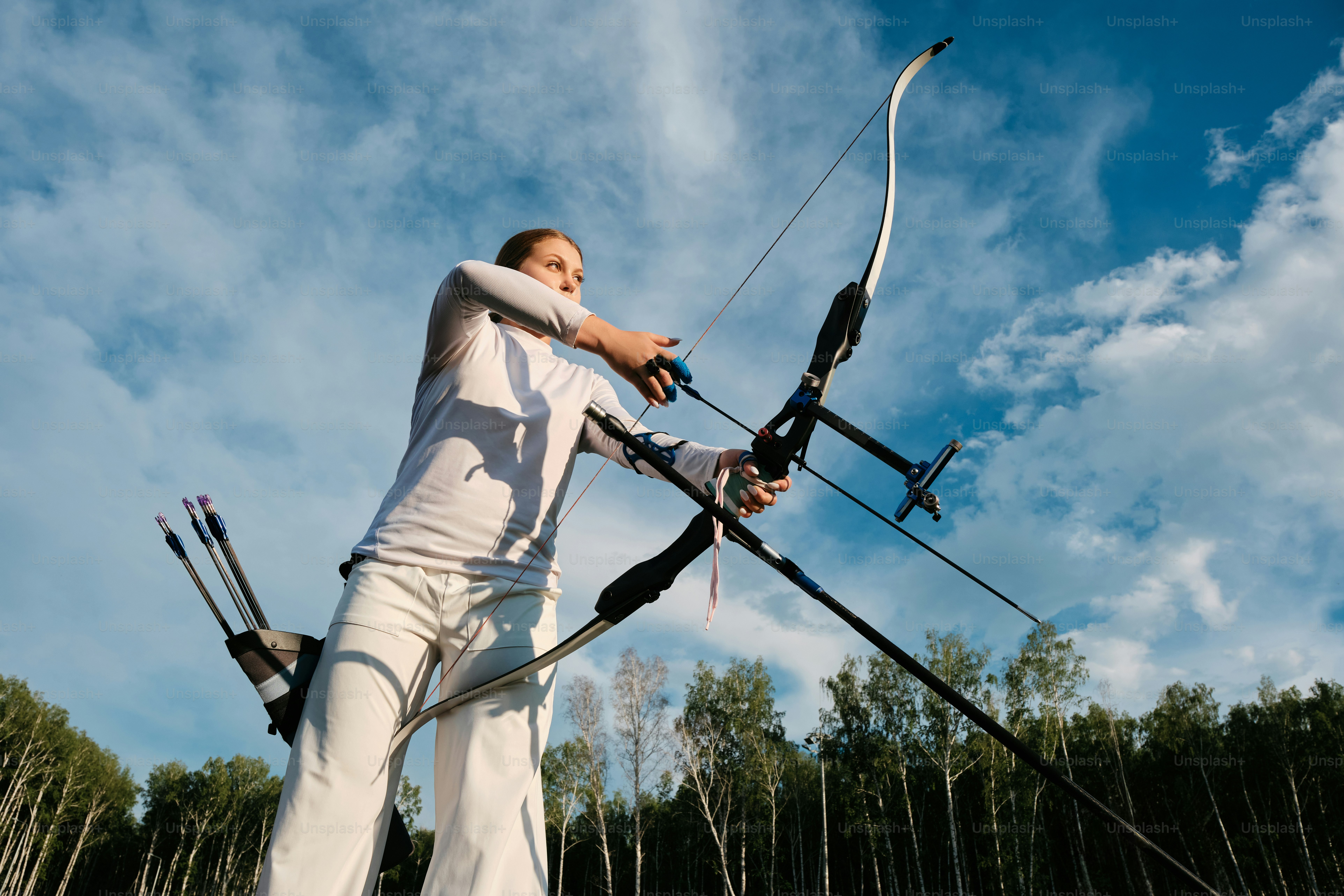 A woman holding a bow and arrow in her hands photo – Archery Image on ...