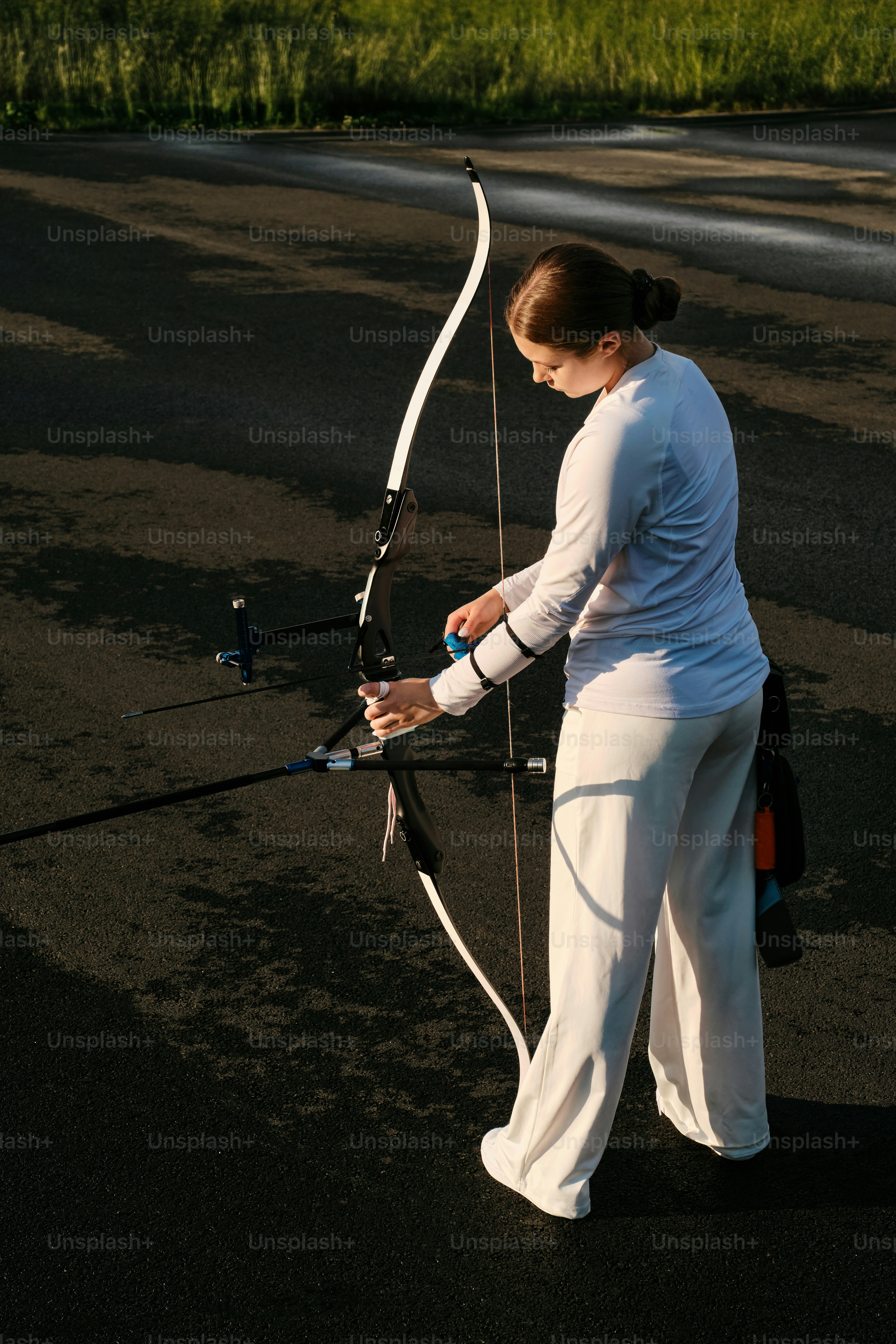 A woman in white holding a bow and arrow photo – Girl Image on Unsplash