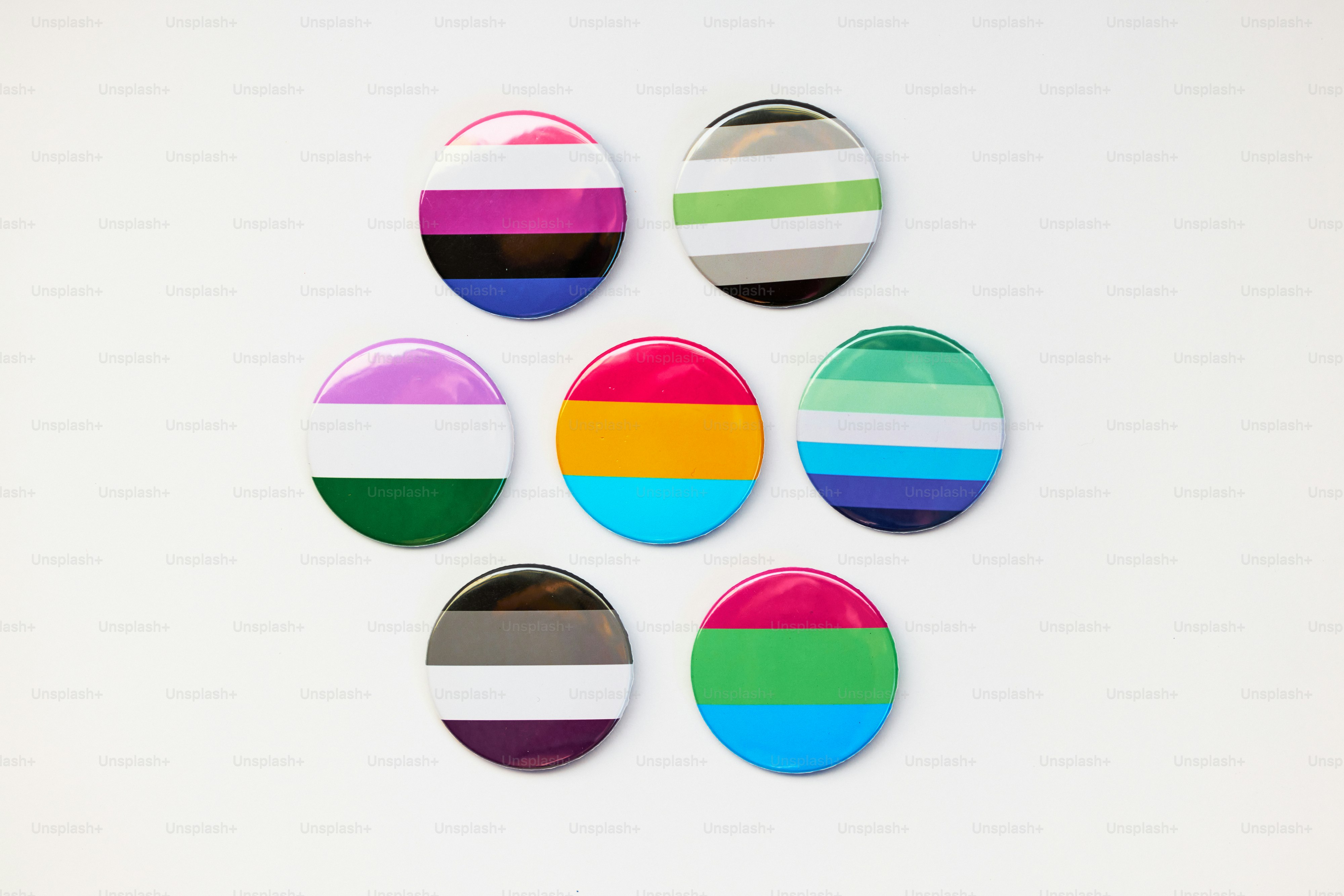A group of multicolored buttons sitting on top of a white wall photo ...