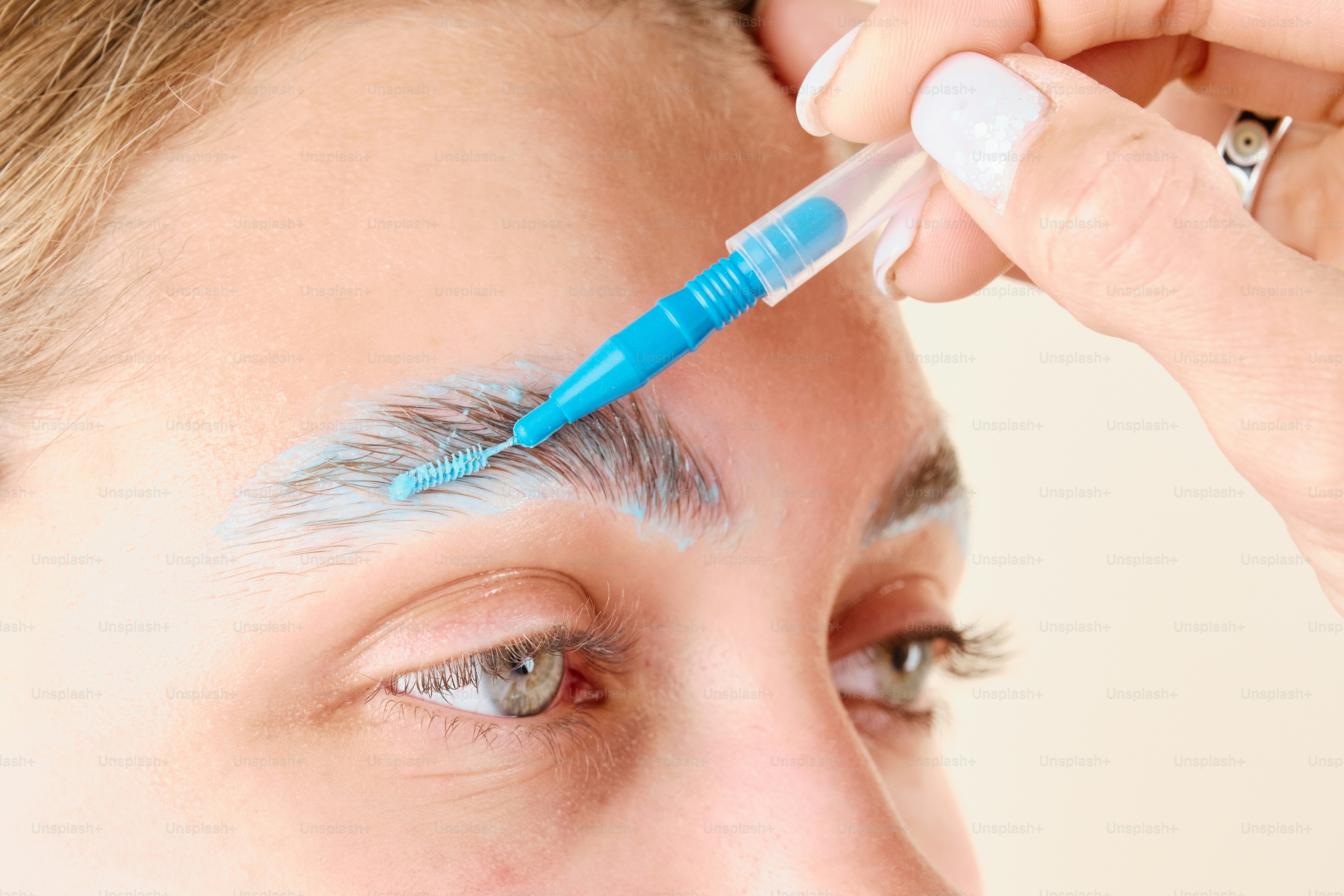 A woman getting her eyebrows done by a doctor photo – Brow lamination ...