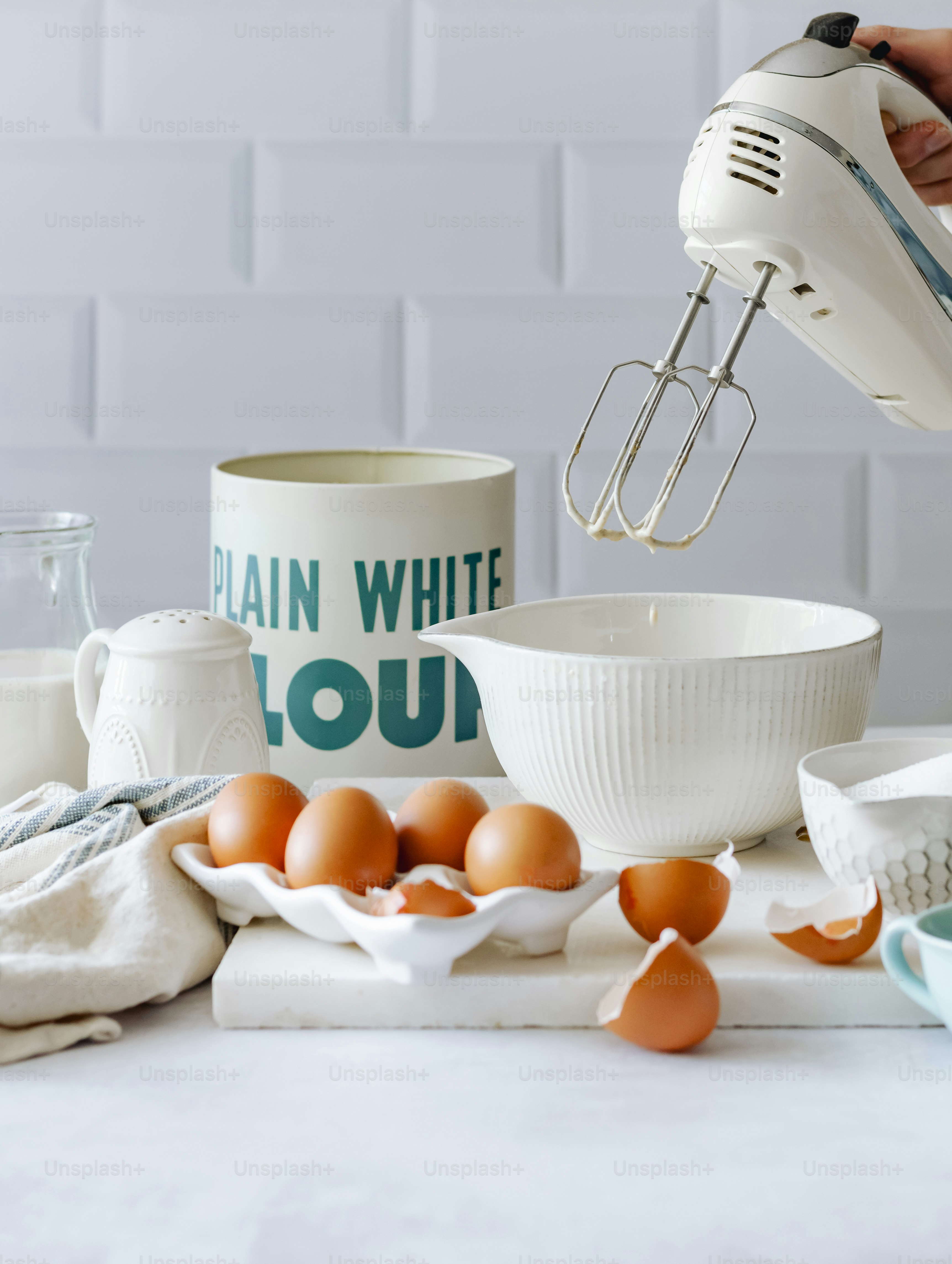 A person mixing eggs in a bowl with a mixer photo – Cooking Image on ...