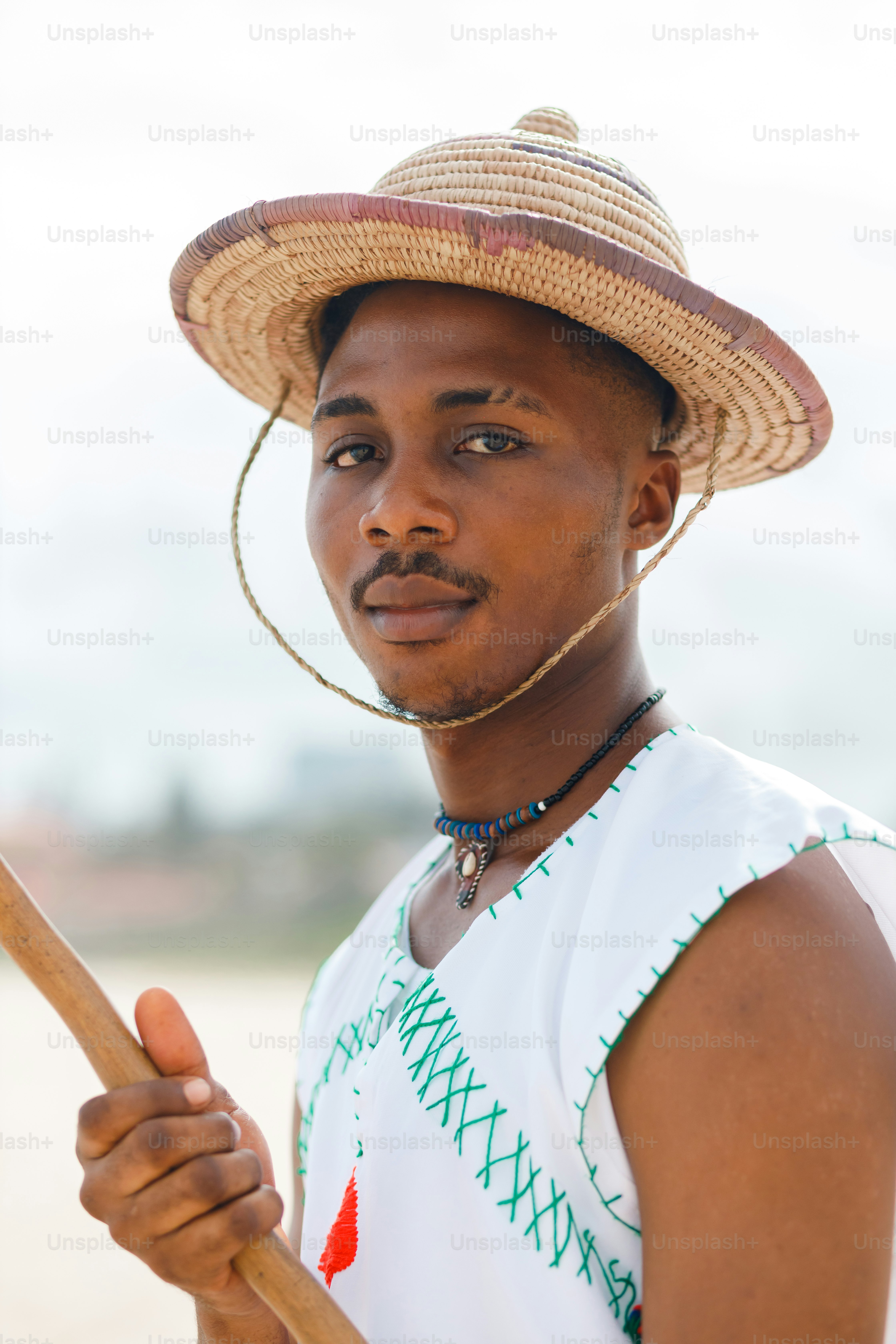 A man in a straw hat holding a stick photo – Nigeria Image on Unsplash