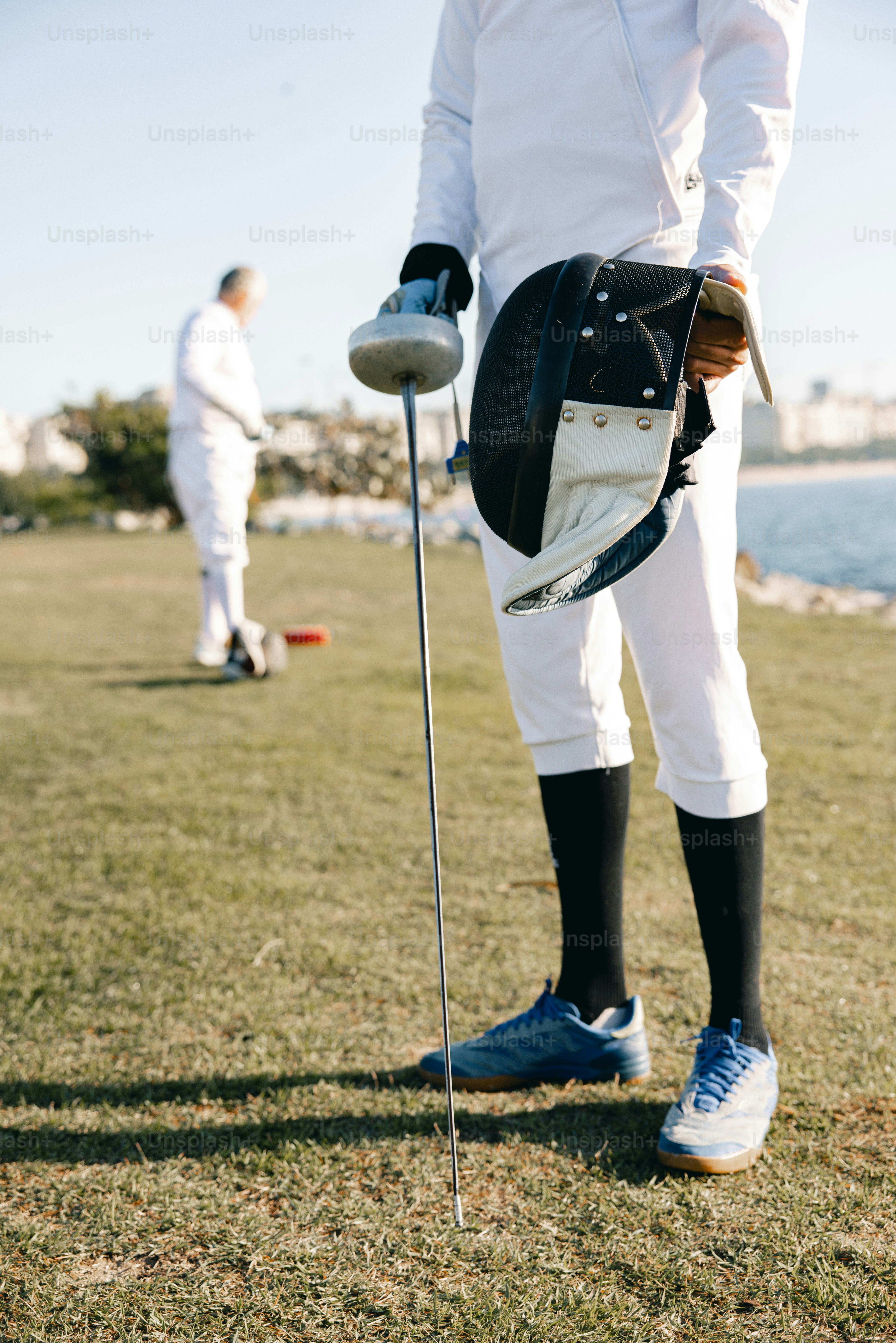 A man standing on top of a lush green field photo – Sword fighting ...
