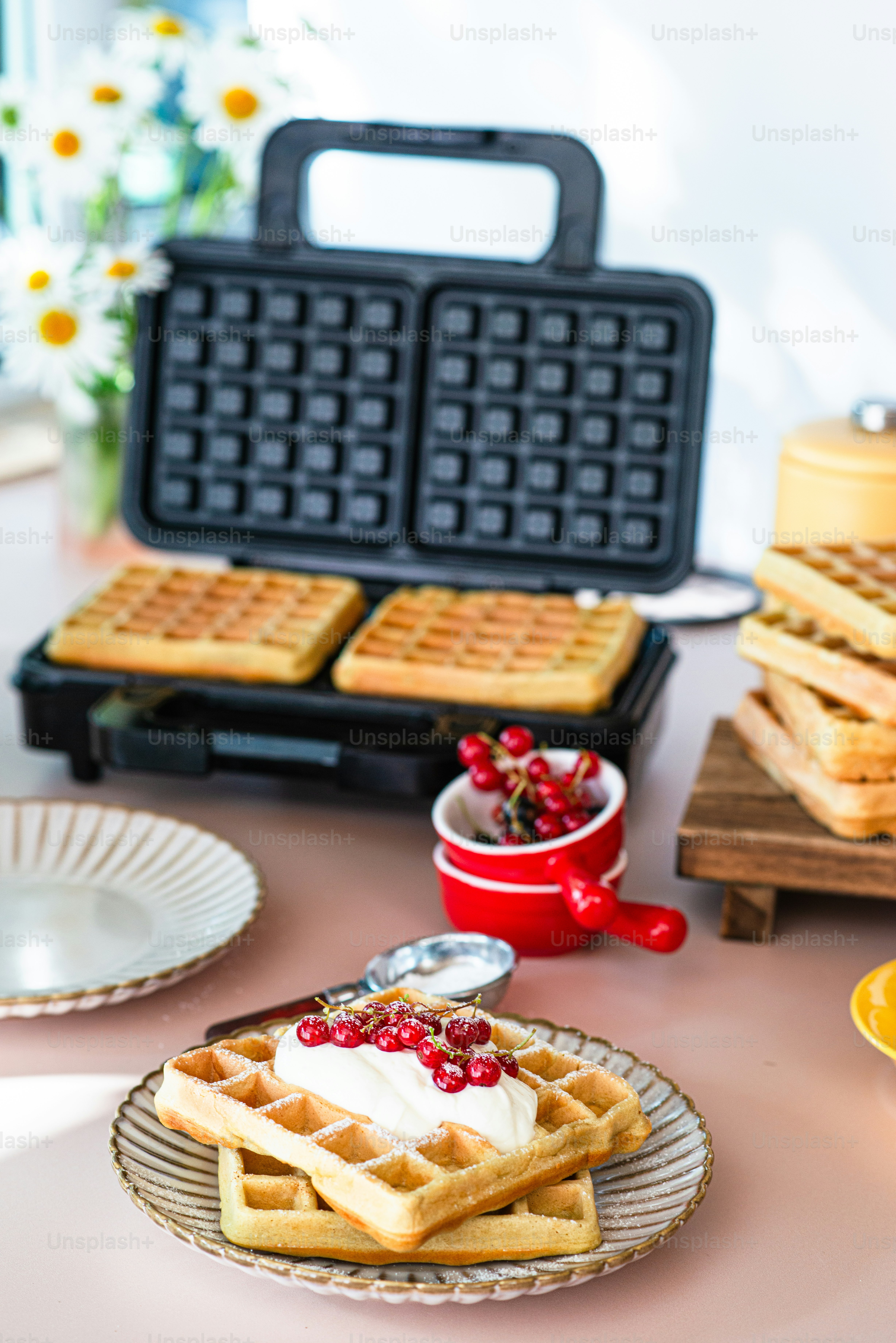 A table topped with waffles and plates of food photo – Waffle maker ...