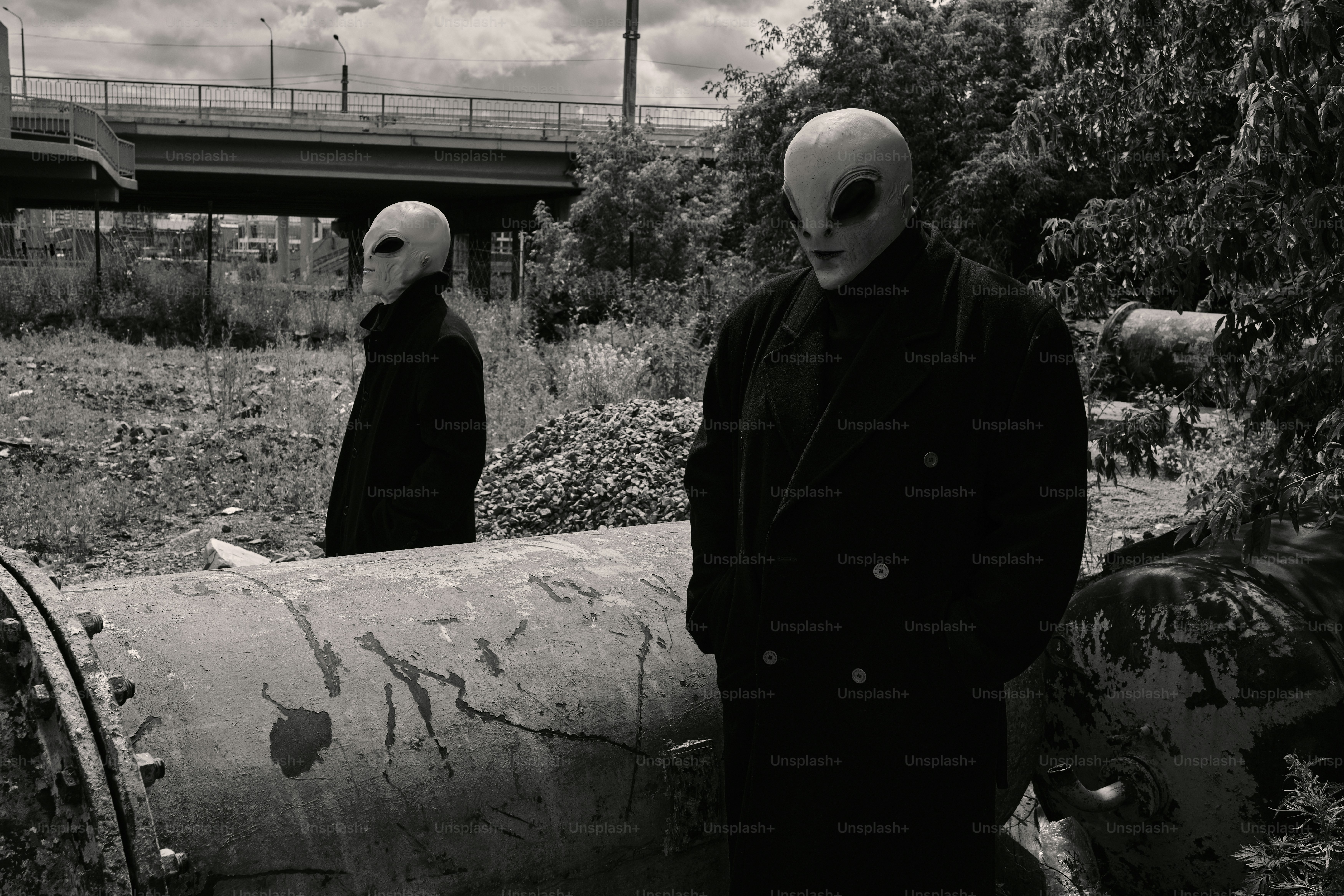 Two people wearing masks standing next to a barrel photo – Aliens Image ...