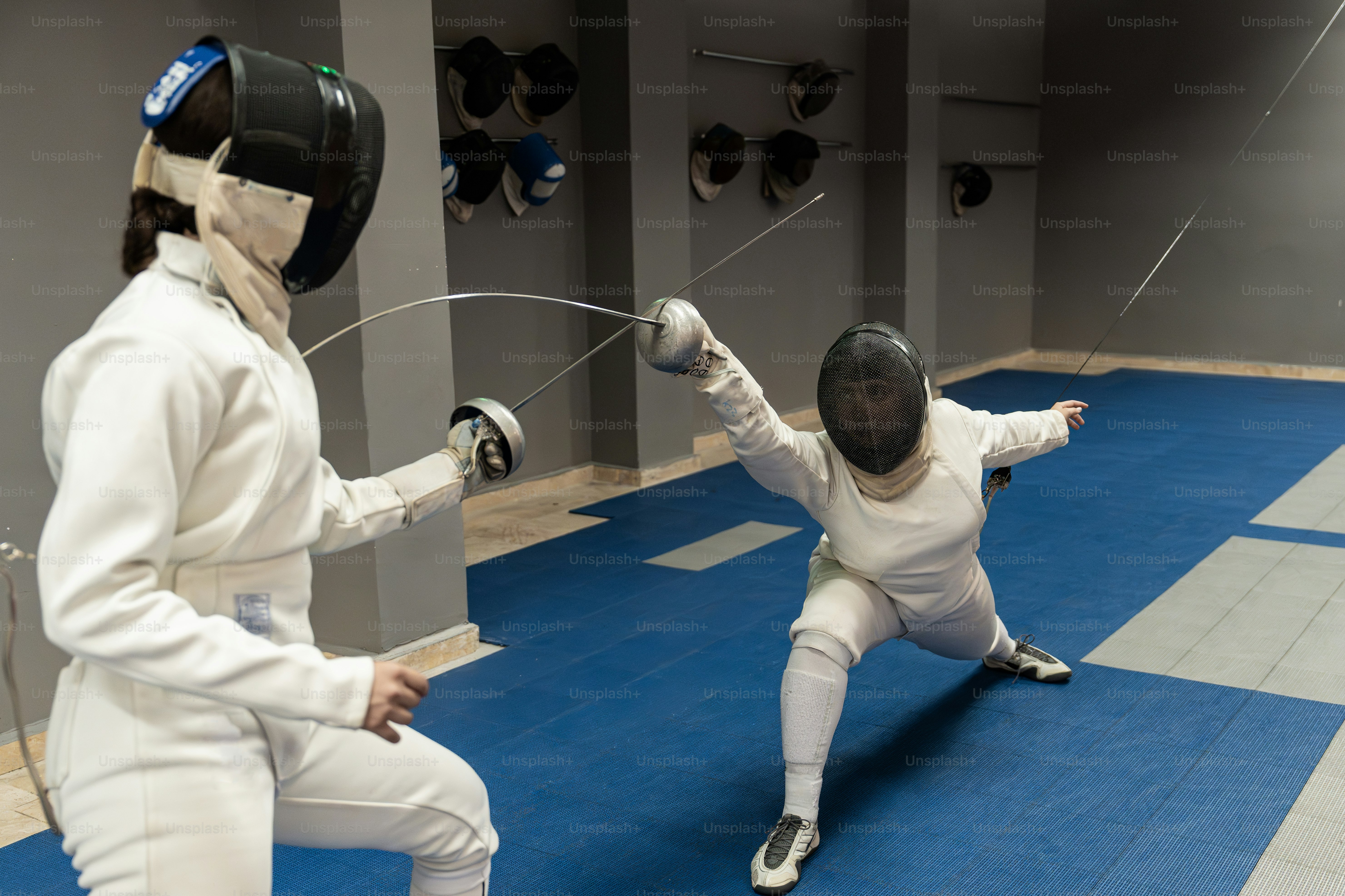 A couple of people in fencing gear in a room photo – Fencing Image on ...
