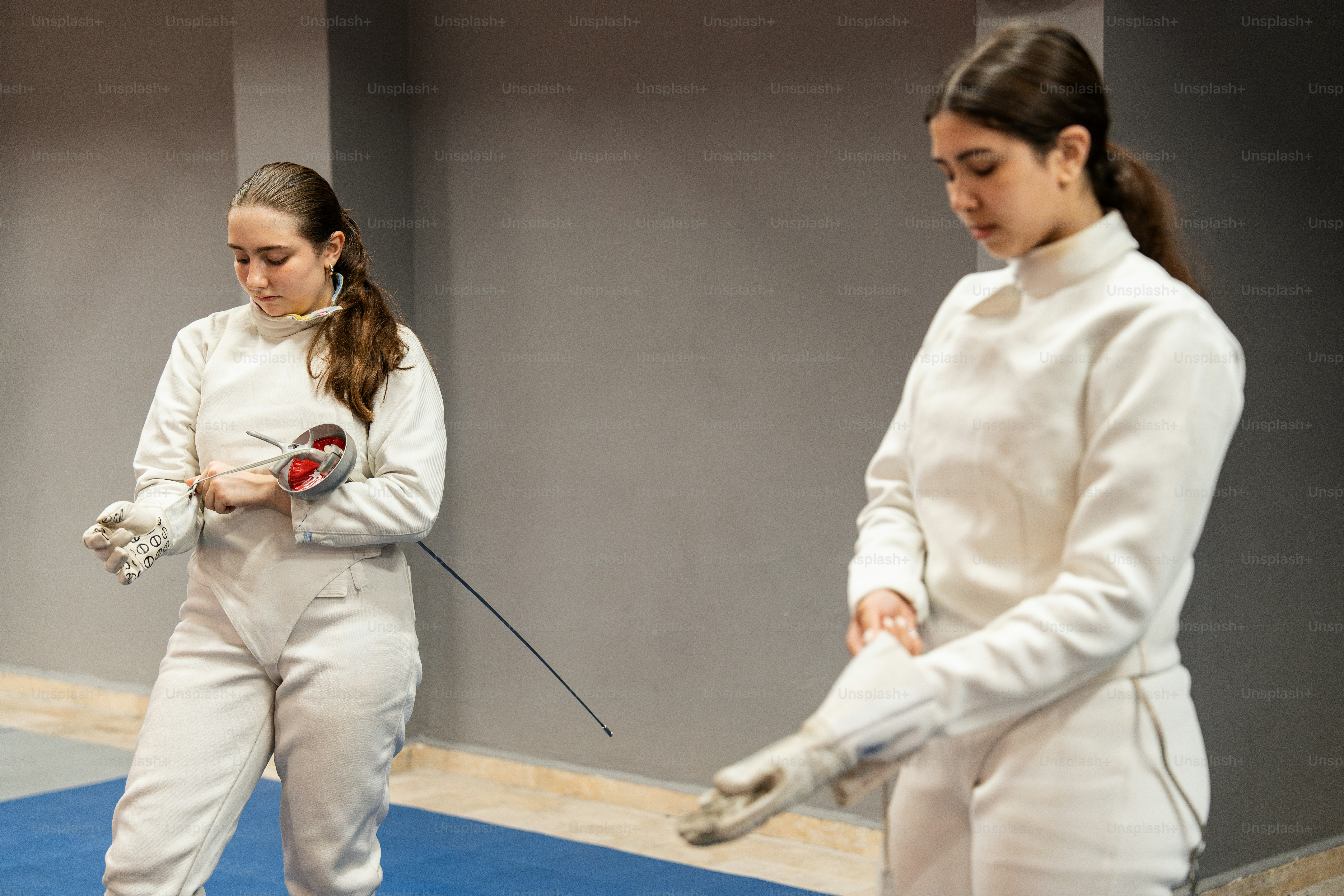 Two women in white fencing suits holding fencing poles photo – Fencing ...