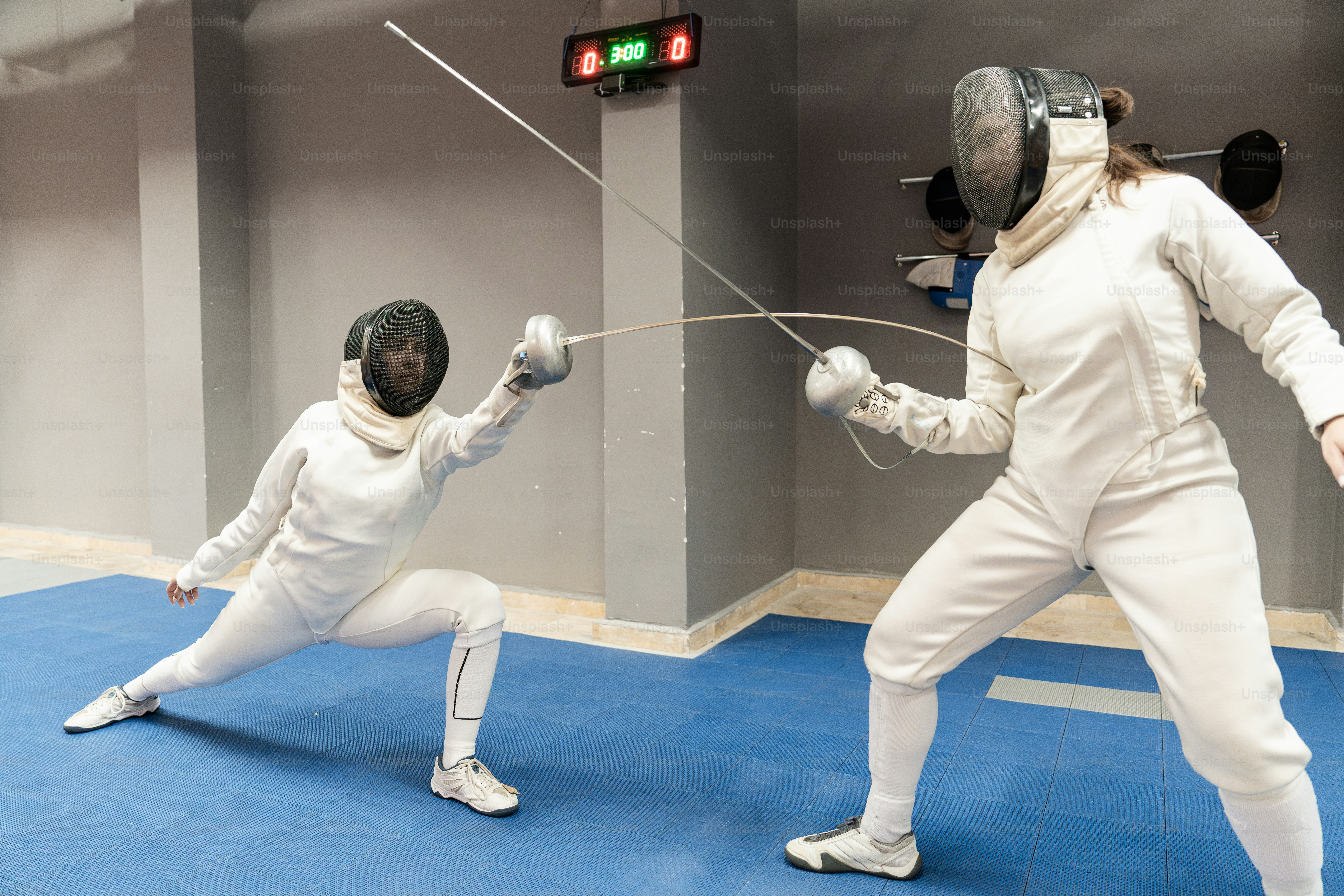 A couple of people in fencing gear in a room photo – Sports Image on ...