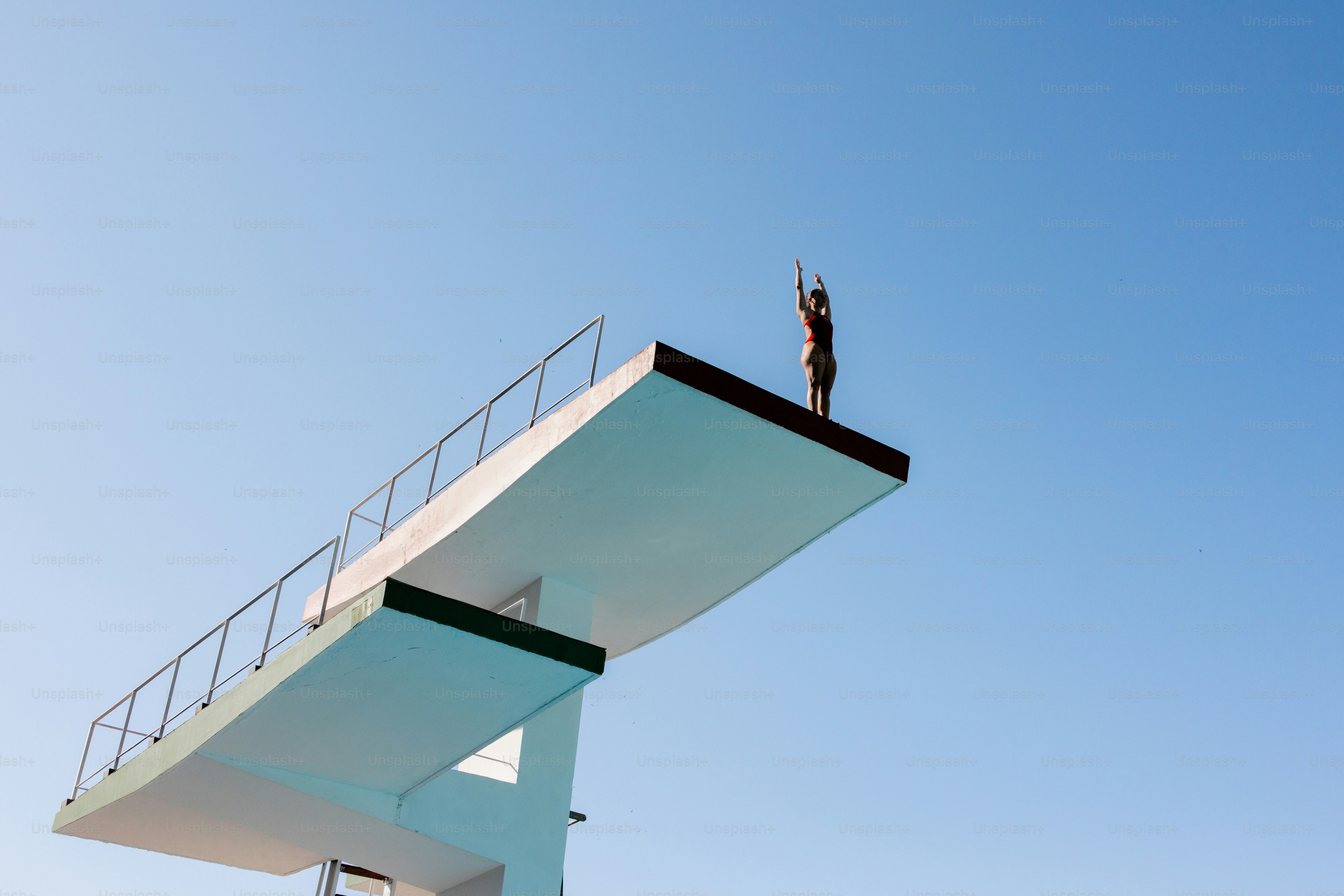 A man standing on top of a tall white structure photo – Athlete Image ...
