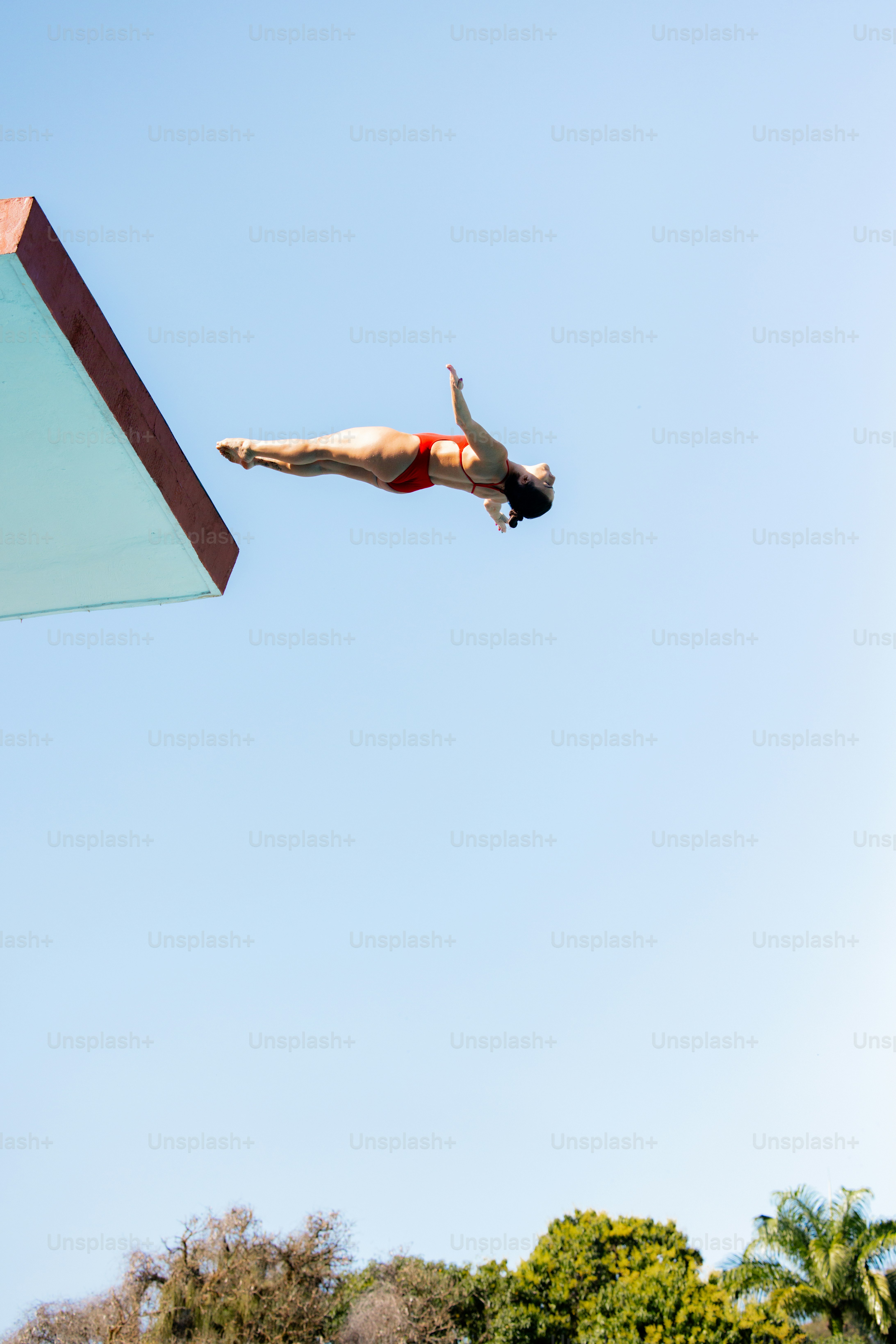 A person diving into a pool with a sky background photo – Olympics ...