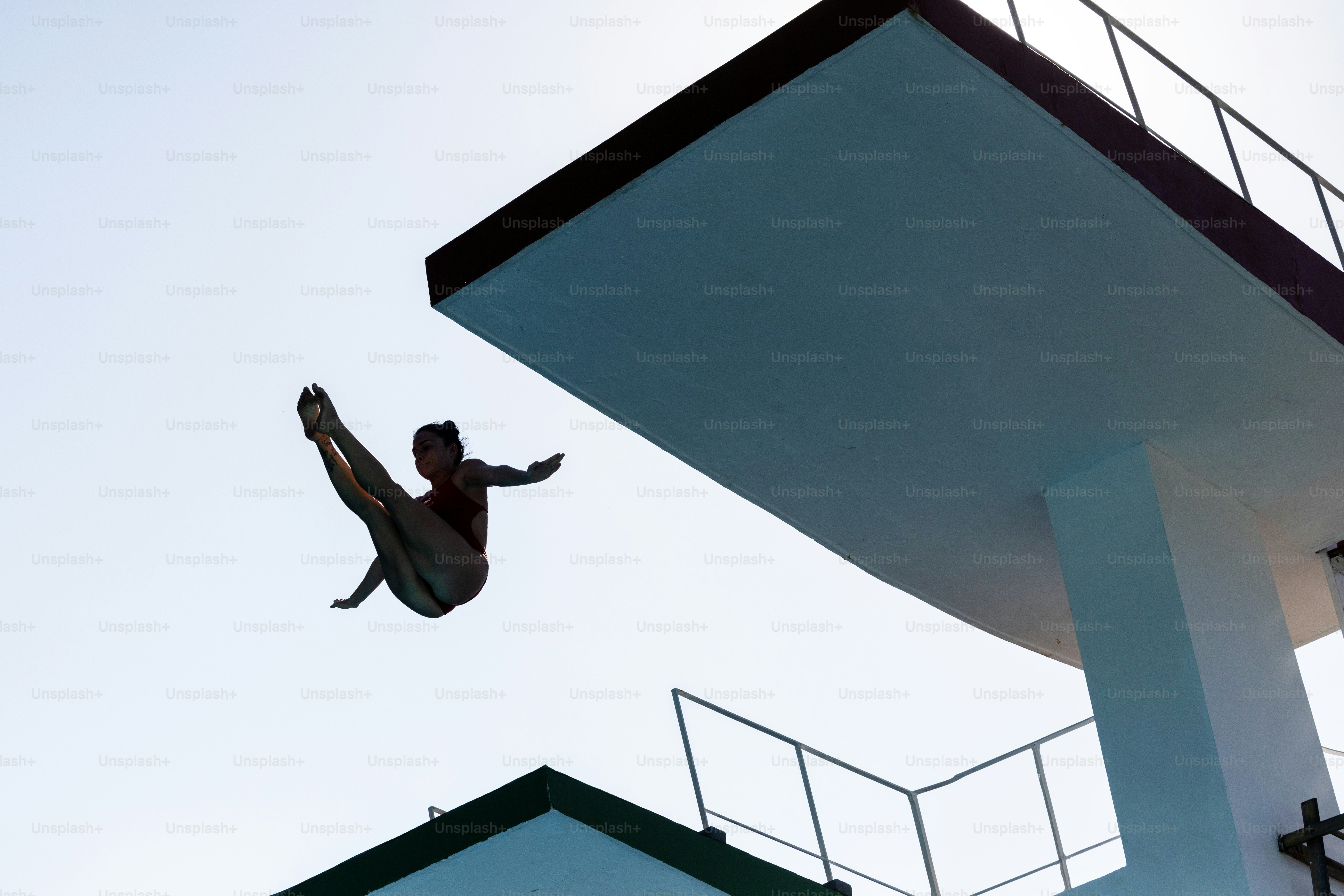 A person jumping off of a building into the air photo – Diving platform ...