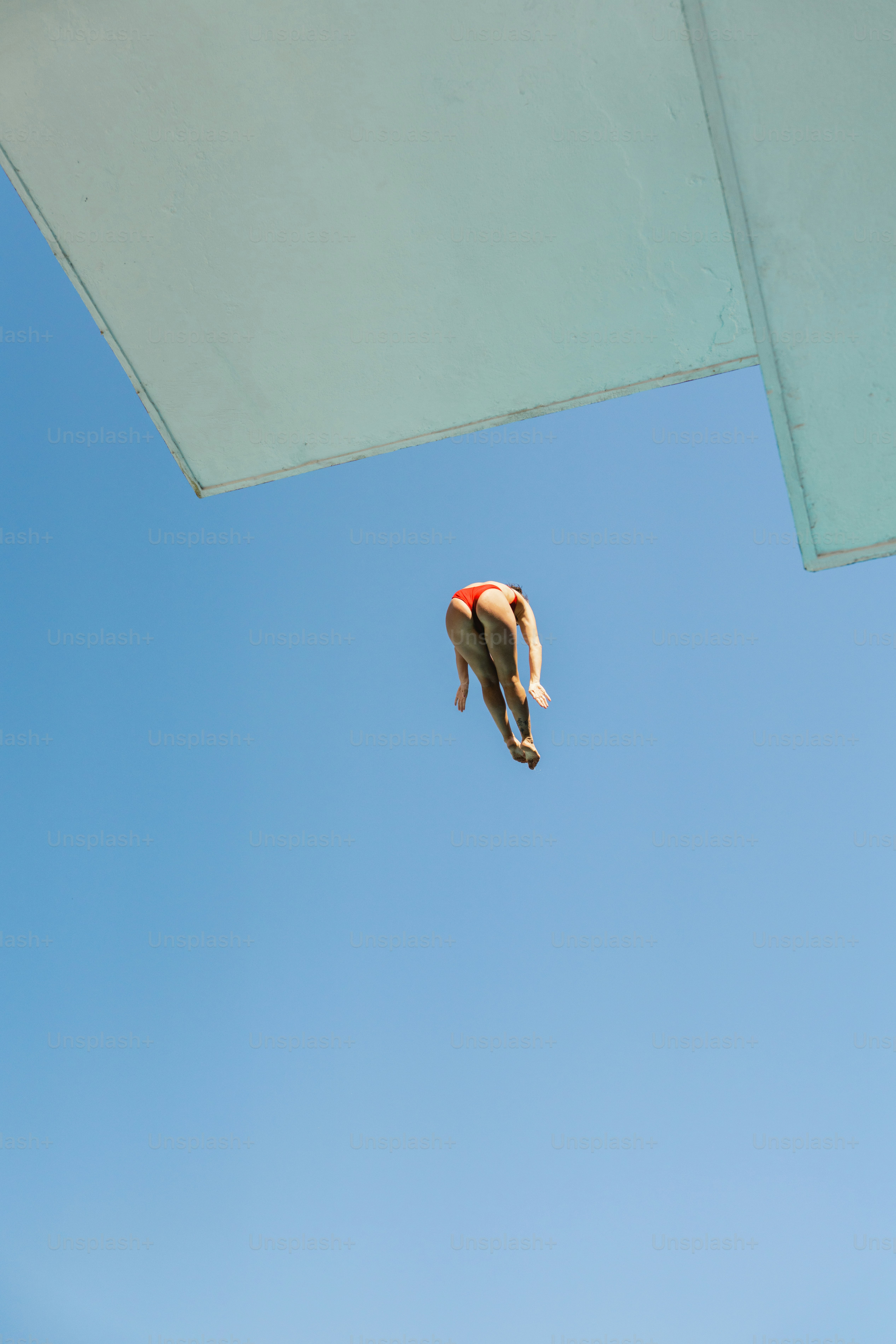 A person jumping into the air from a swimming pool photo – Woman Image ...