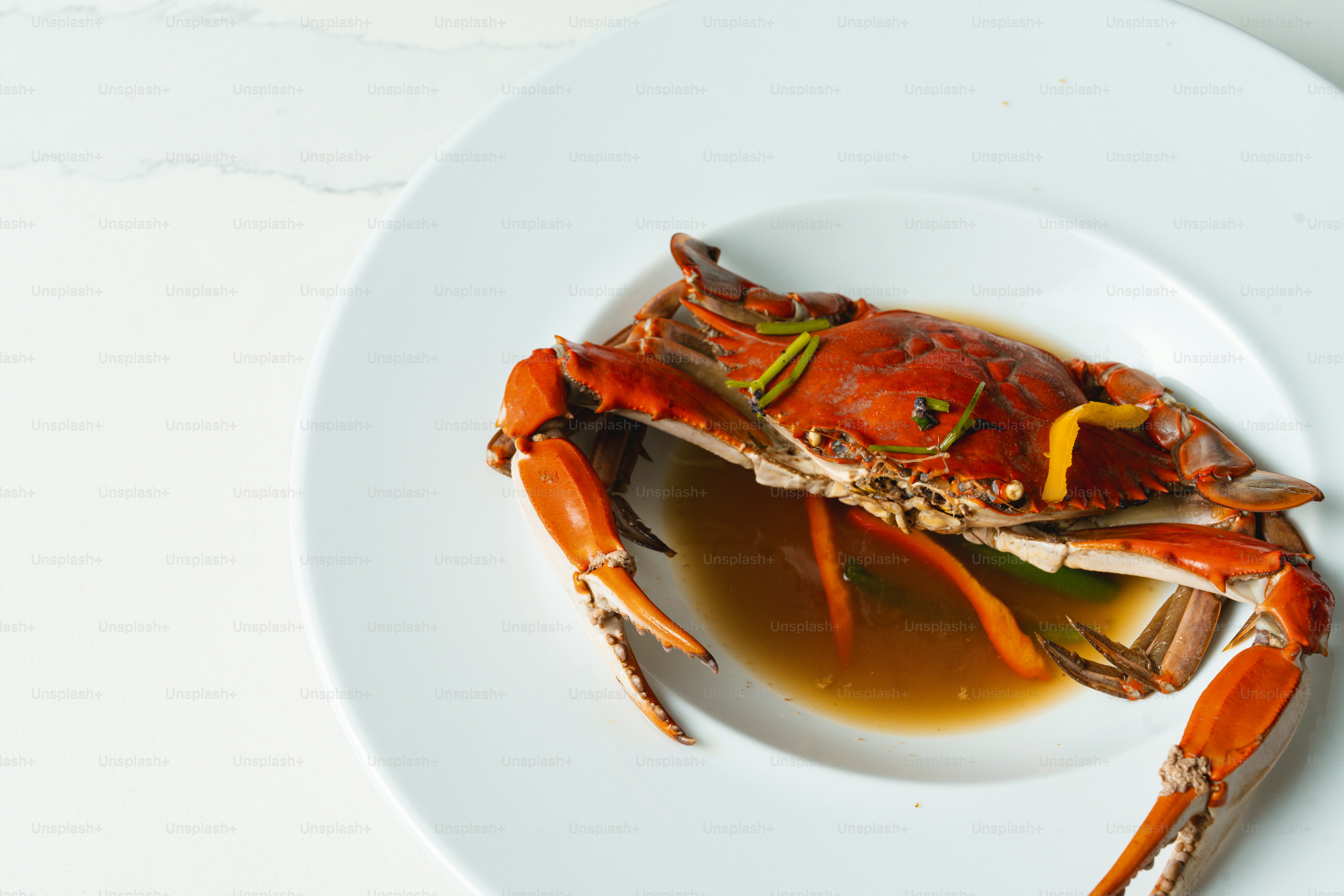A white plate topped with a cooked crab next to a donut photo – Seafood ...
