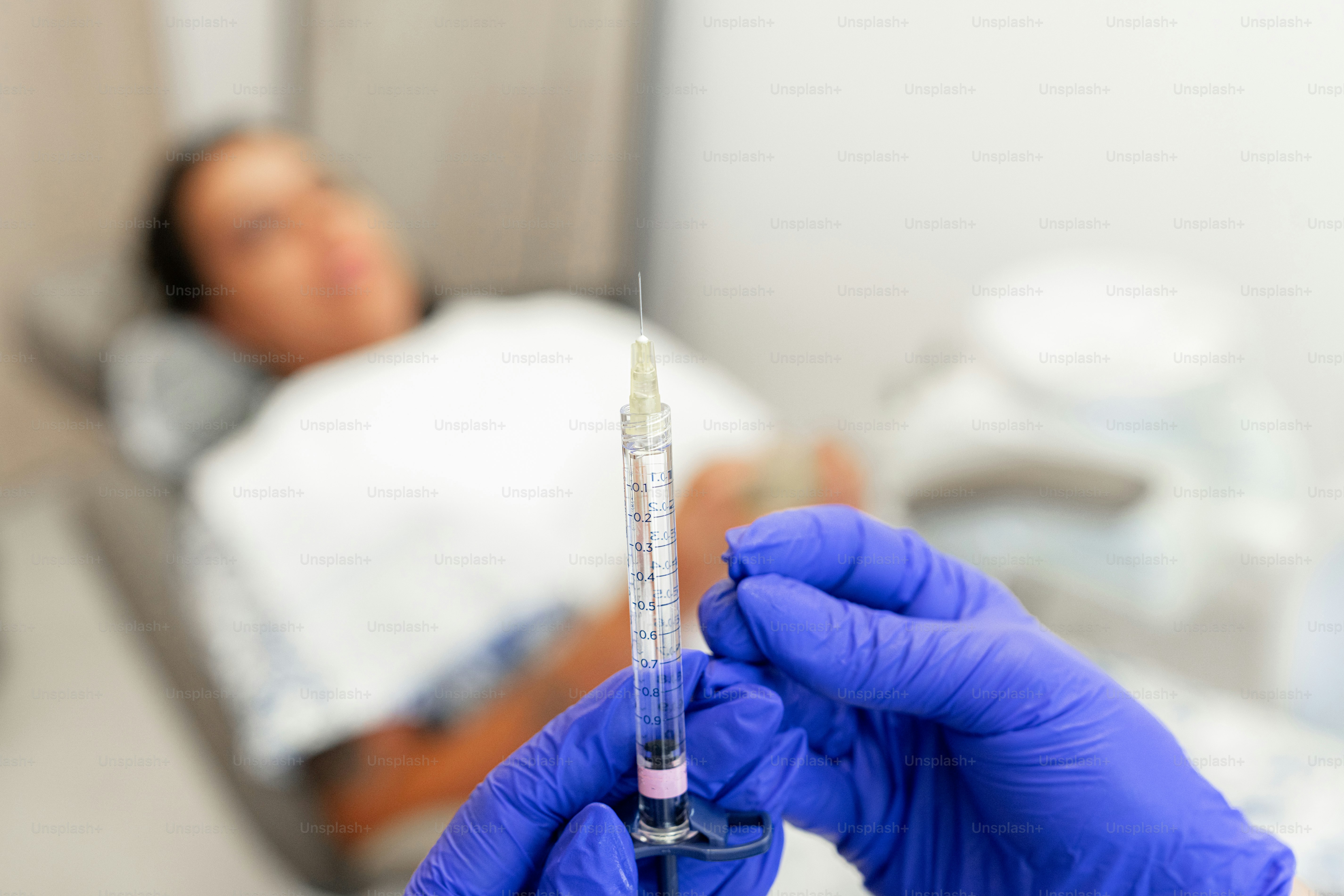 A person in a hospital bed with a needle in their hand photo – Botox ...