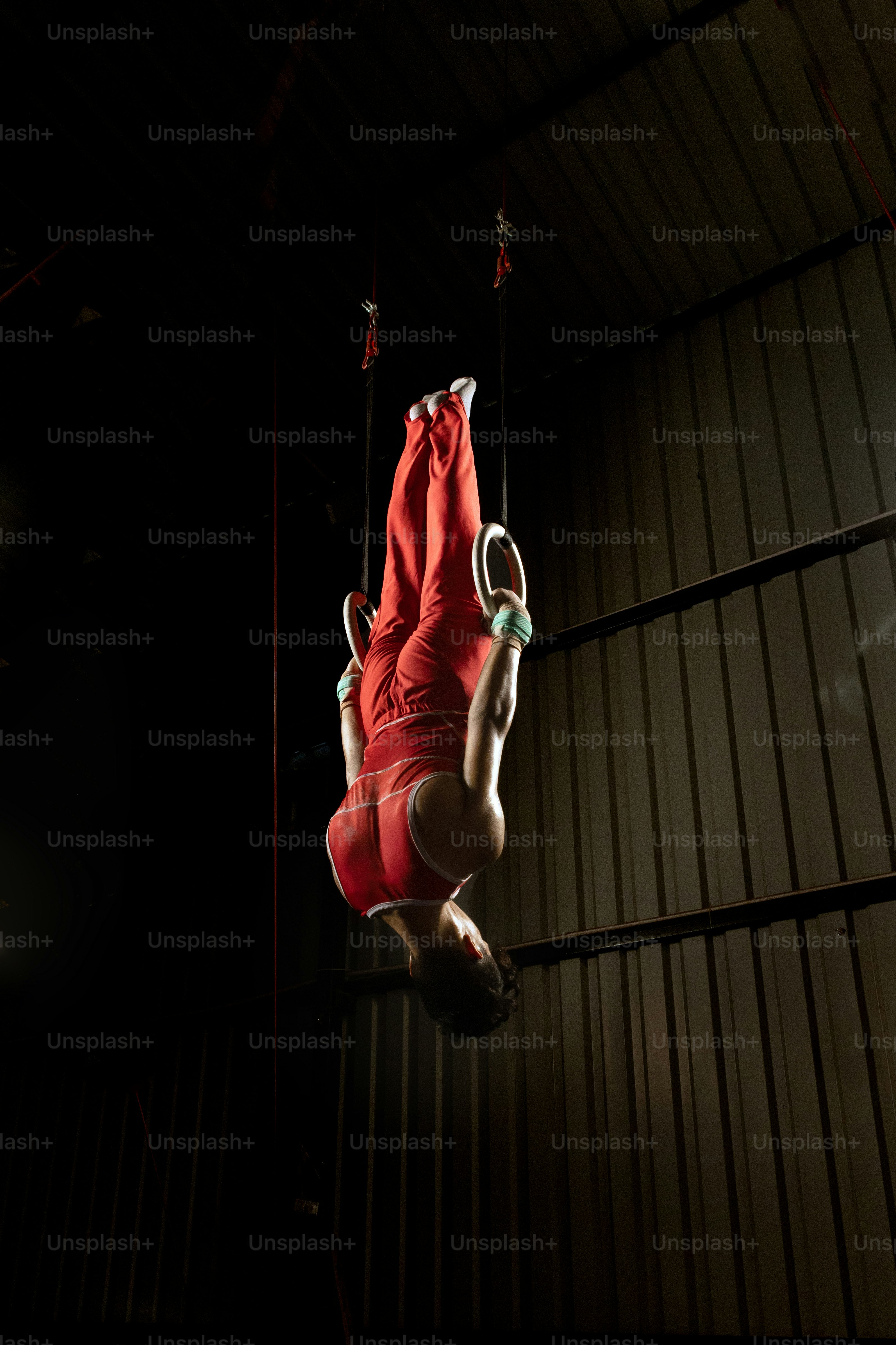 A person hanging upside down on a rope photo – Gymnastic rings Image on ...