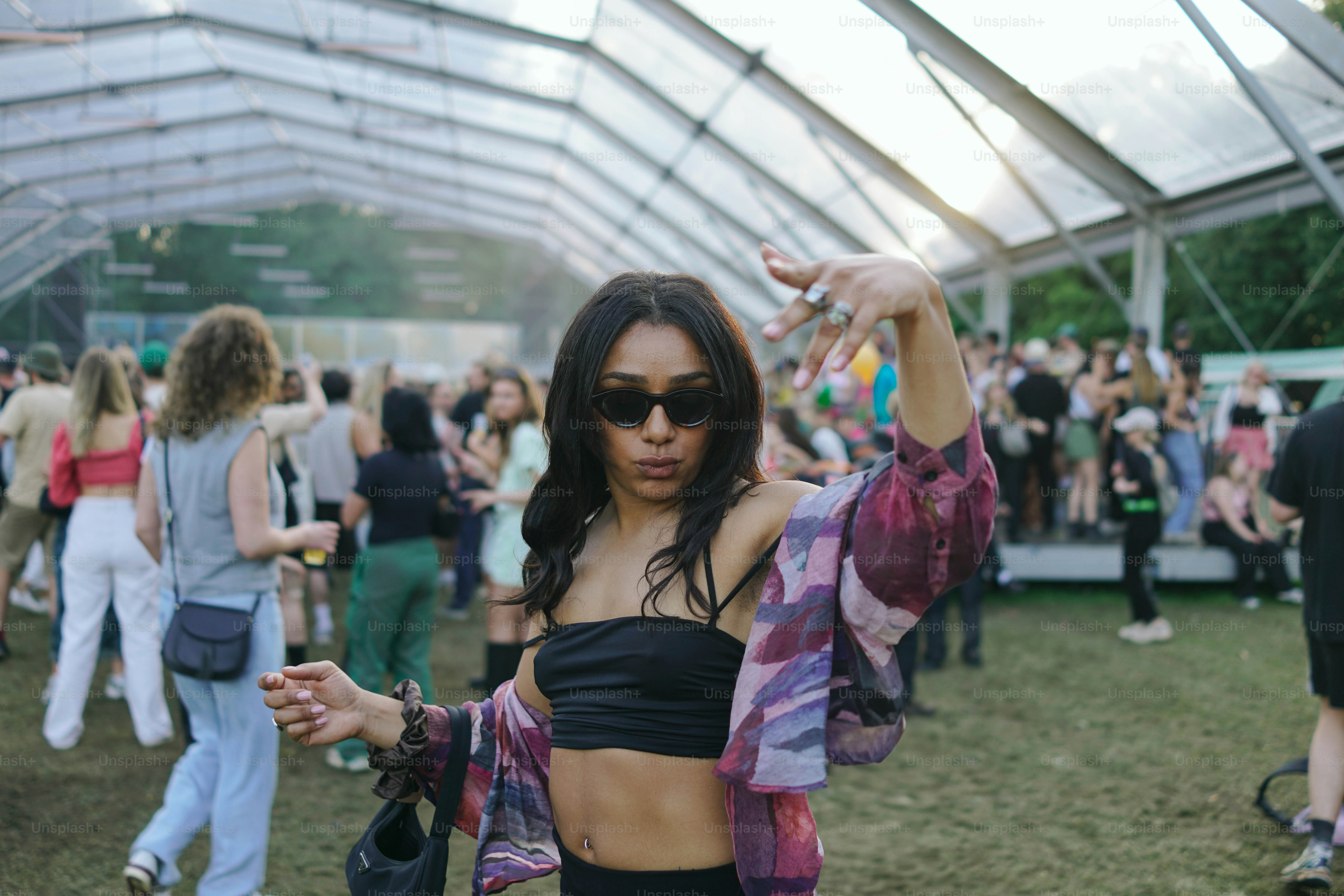 A woman in a crop top dancing at a music festival photo – Festival ...
