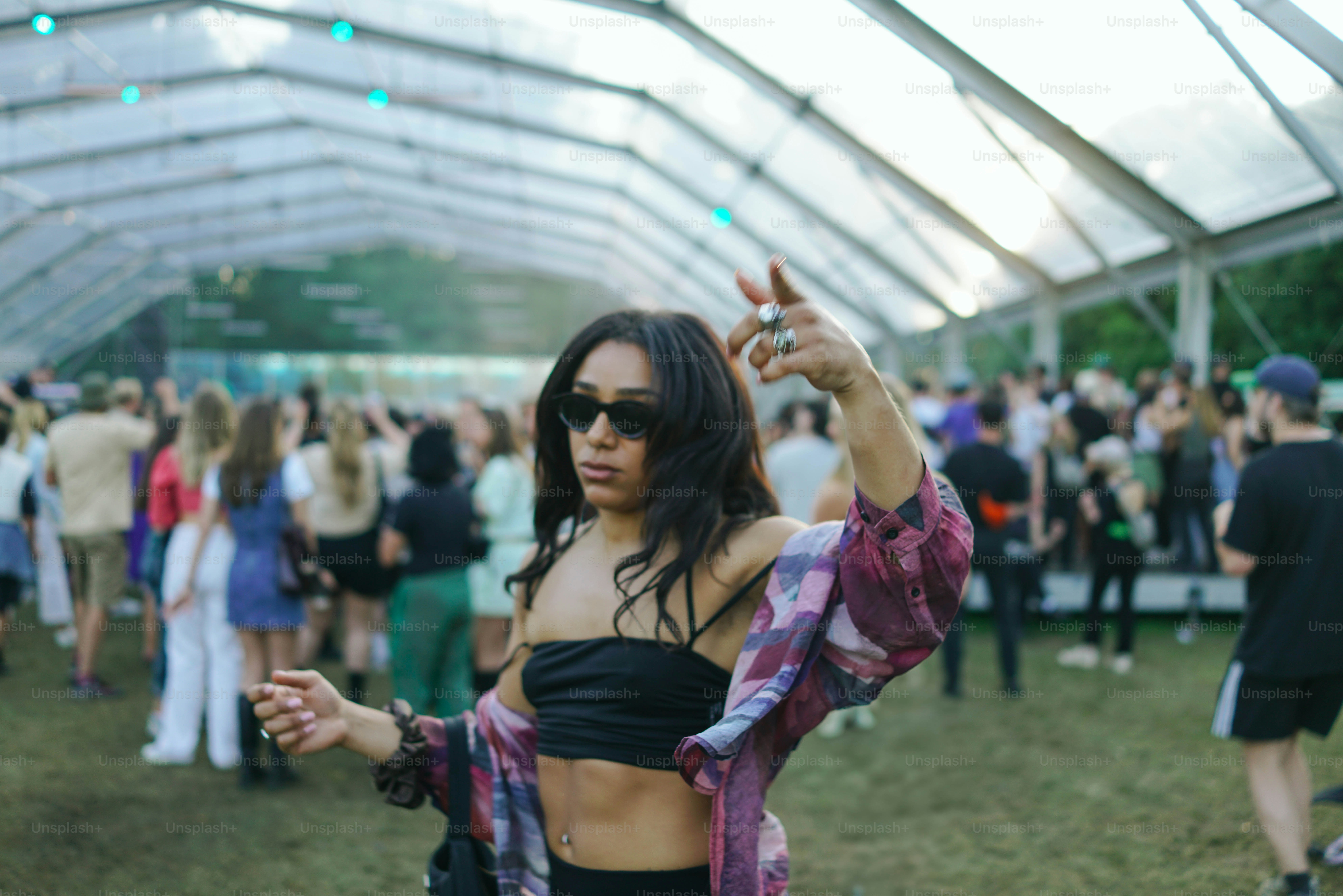 A woman in a crop top dancing at a music festival photo – Girl Image on ...