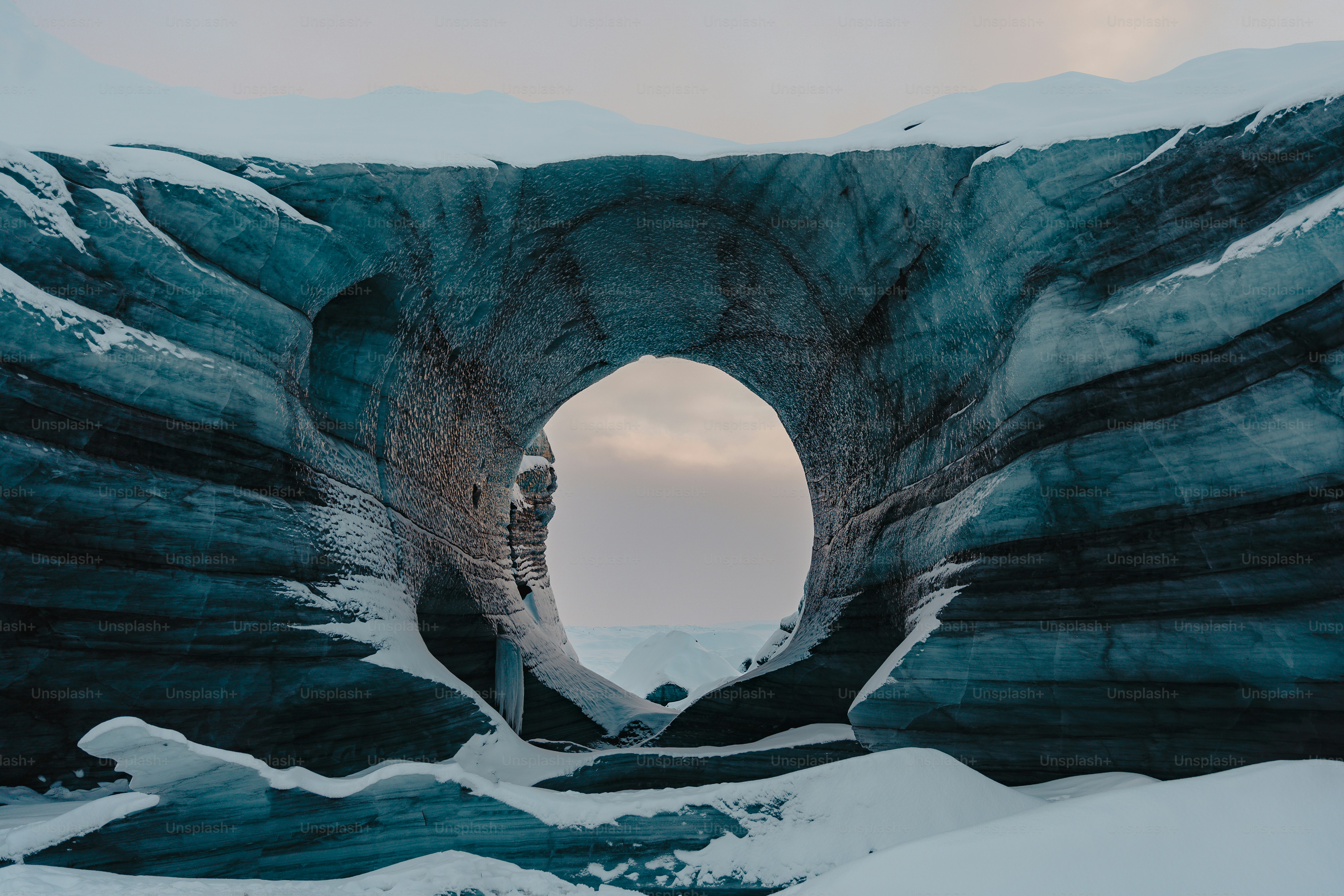 A large ice arch in the middle of a snowy landscape photo – Travel ...