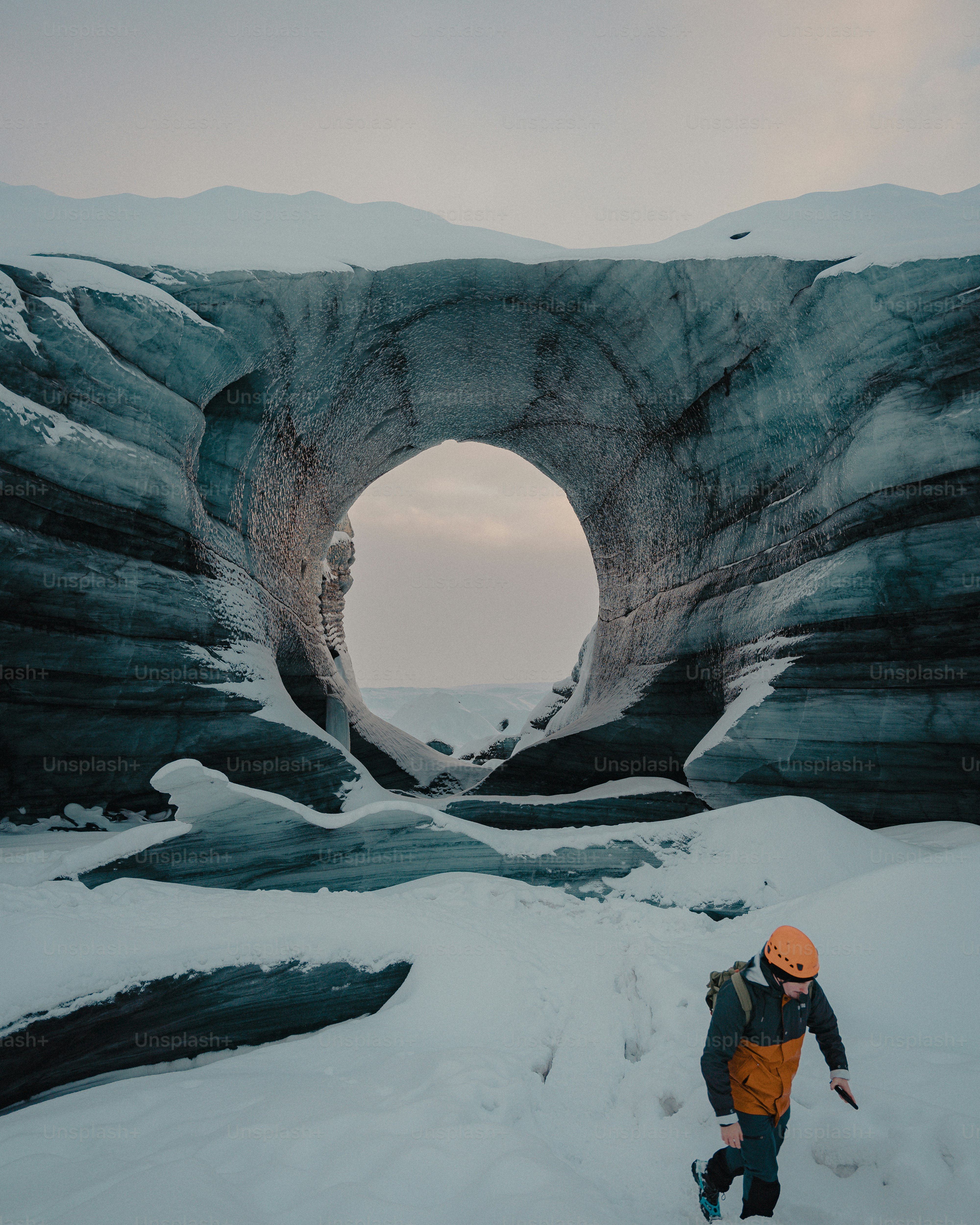 A large ice arch in the middle of a snowy landscape photo – Travel ...