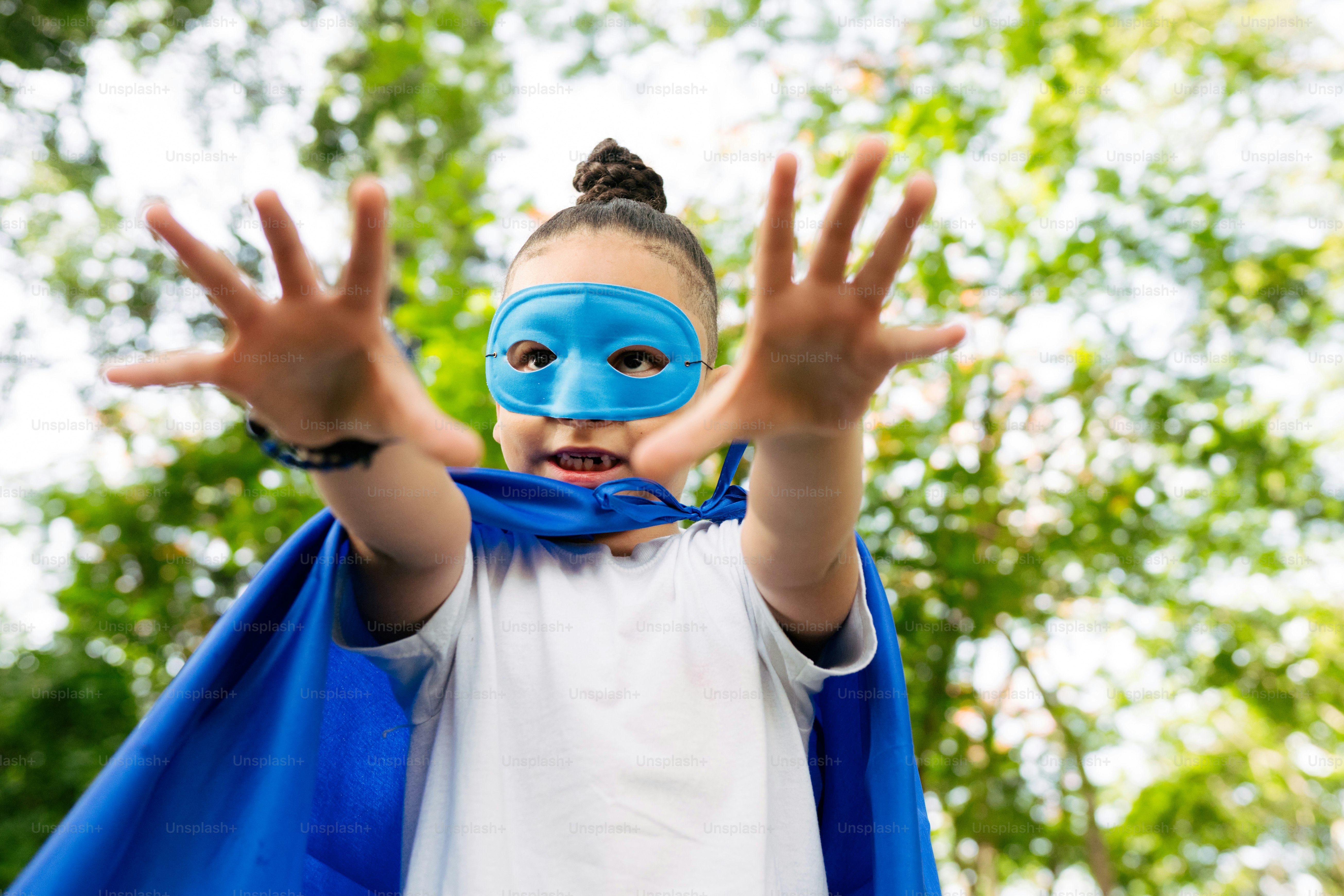 Una niña con una máscara azul y una capa azul foto – Imagen de ...