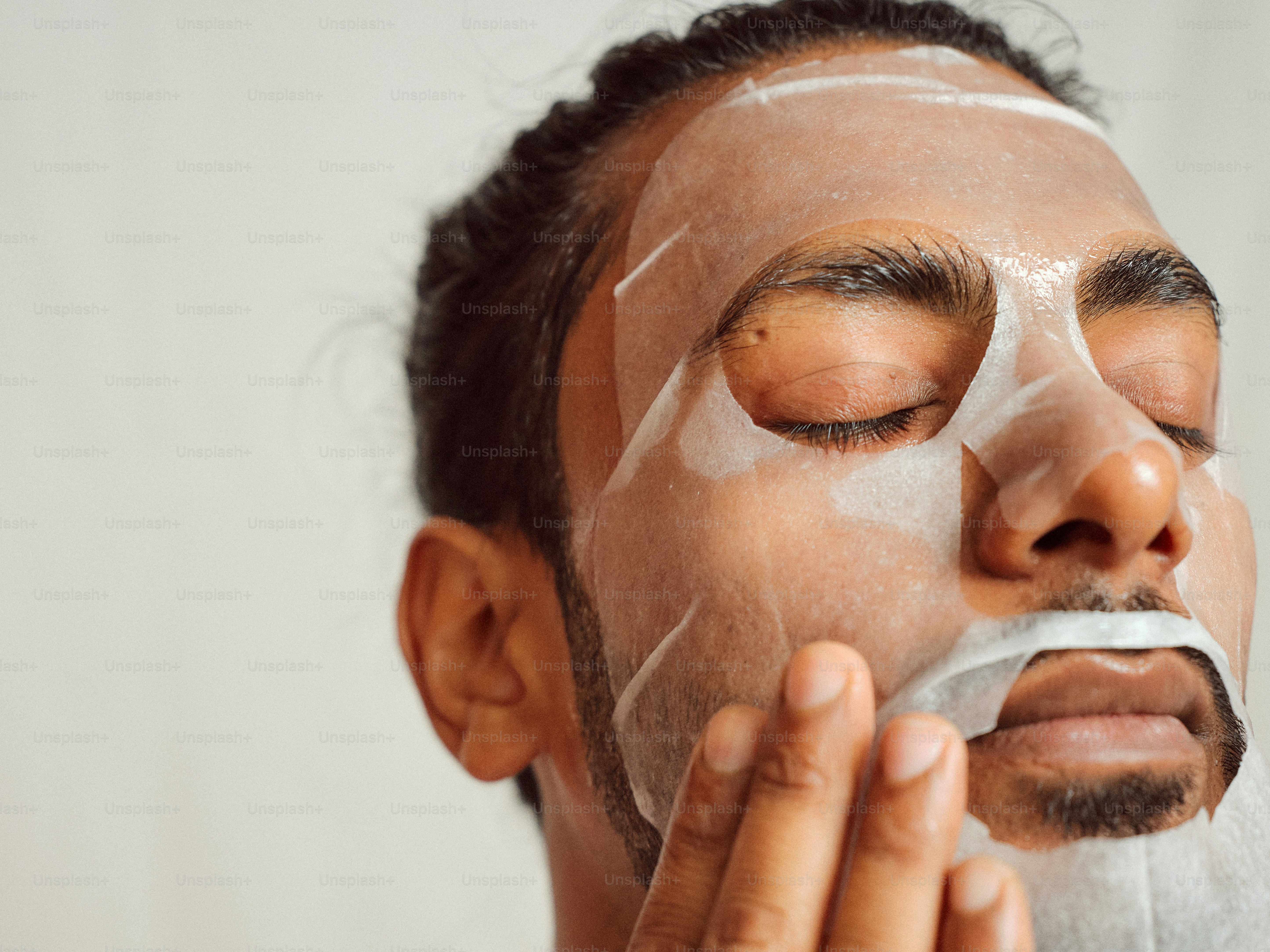 A man shaving his face with a facial mask on photo – Selfcare Image on ...
